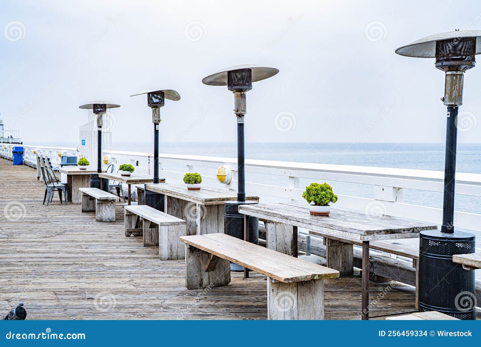 Wooden Benches and Tables Placed on a Bridge with a View of a Sea Stock ...