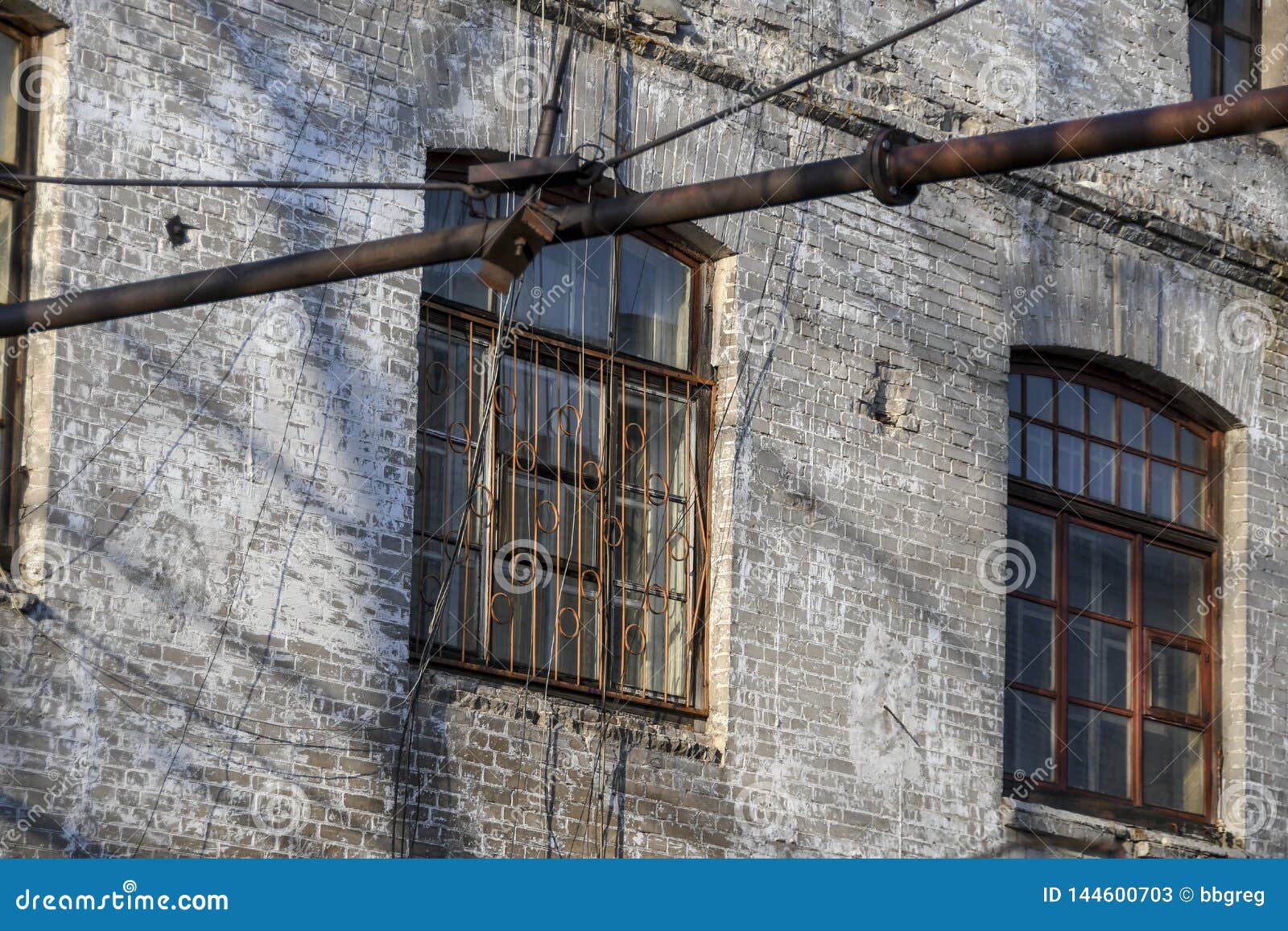 Old Worn Rounded Window with Rusty Grid in a Brick Building. Industrial ...