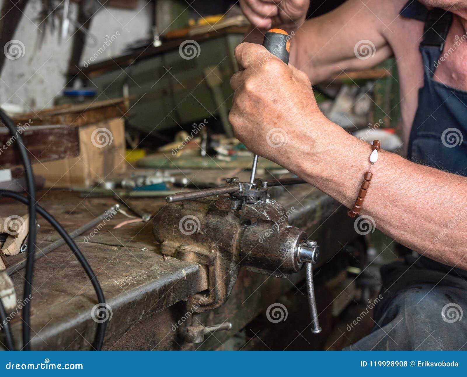 Older Man Sitting at Workbench and Working. Human`s Hands in Process of ...
