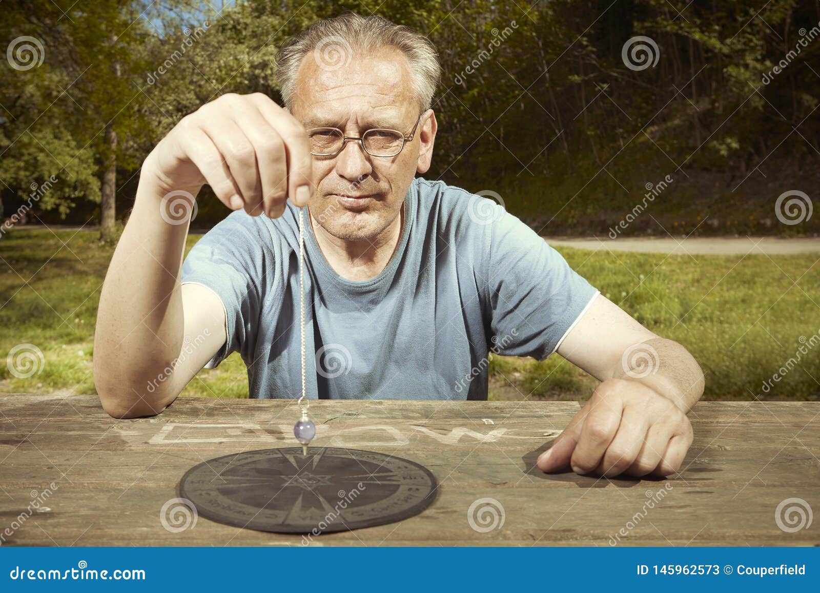 Aging Man Talking with Ghosts in Park with Pendulum and Table Stock ...