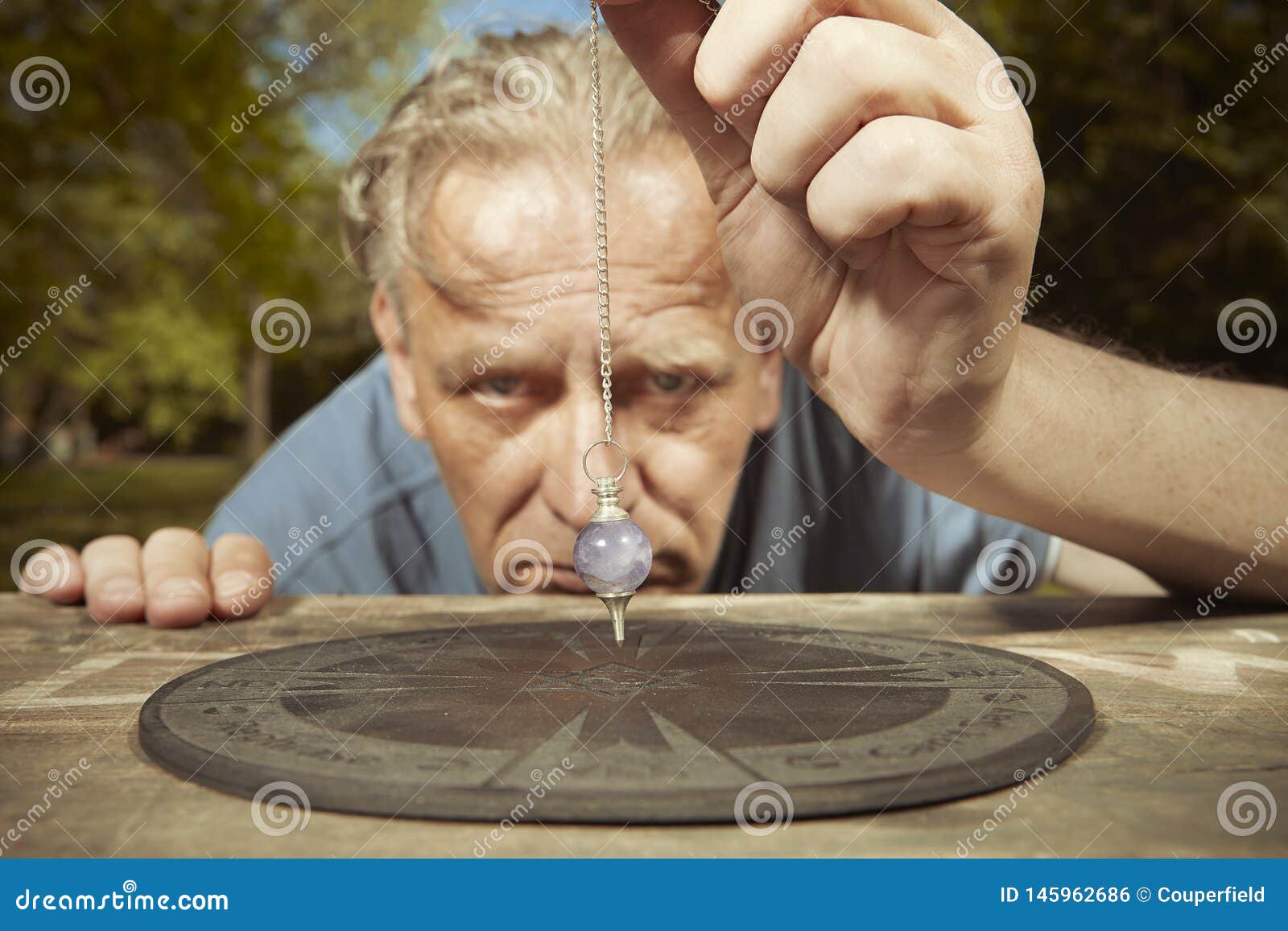 Aging Man Talking with Ghosts in Park with Pendulum and Table Stock ...