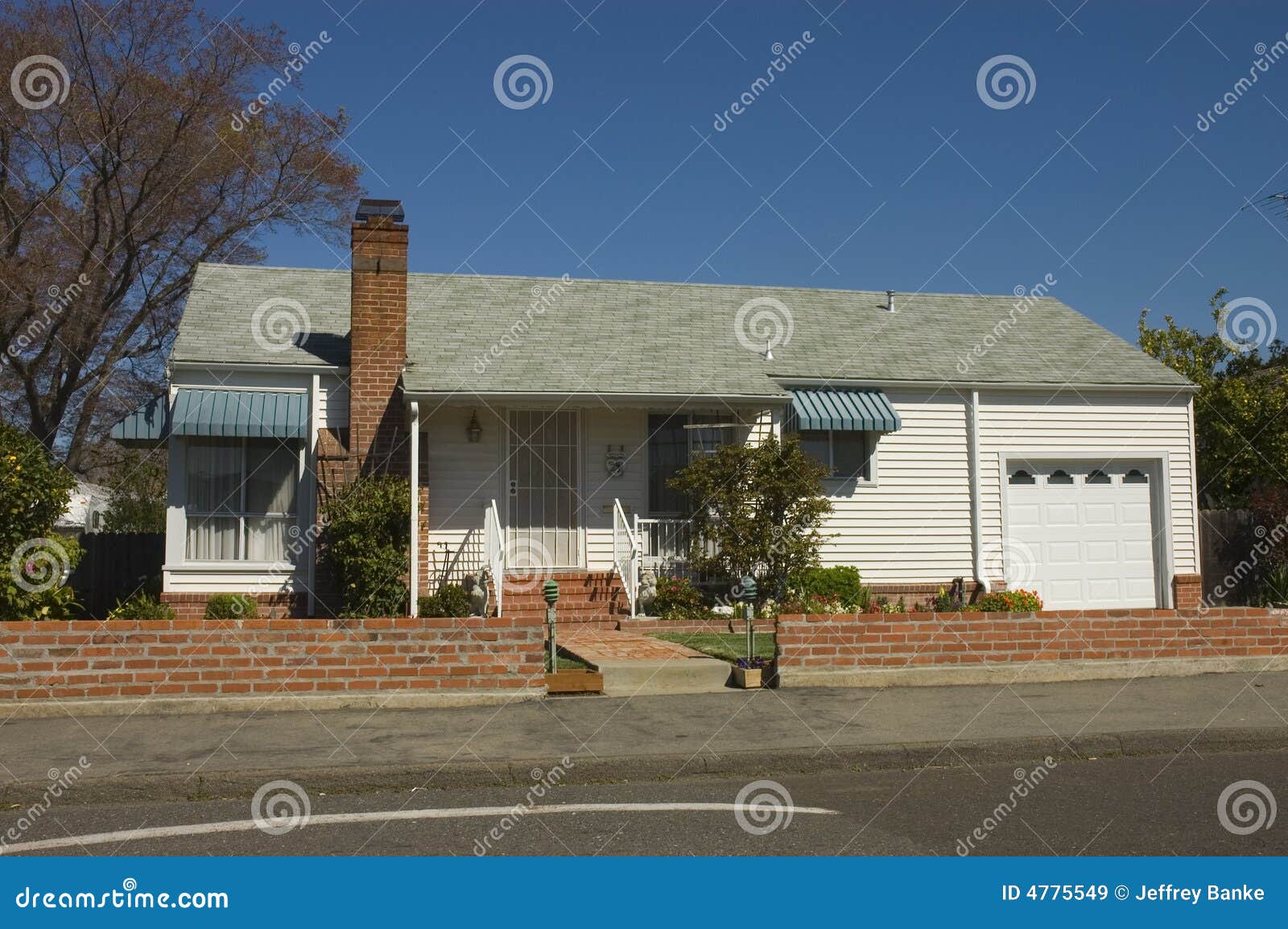 Modest Home Proudly Displaying American Flag And Hanging Flower Stock ...