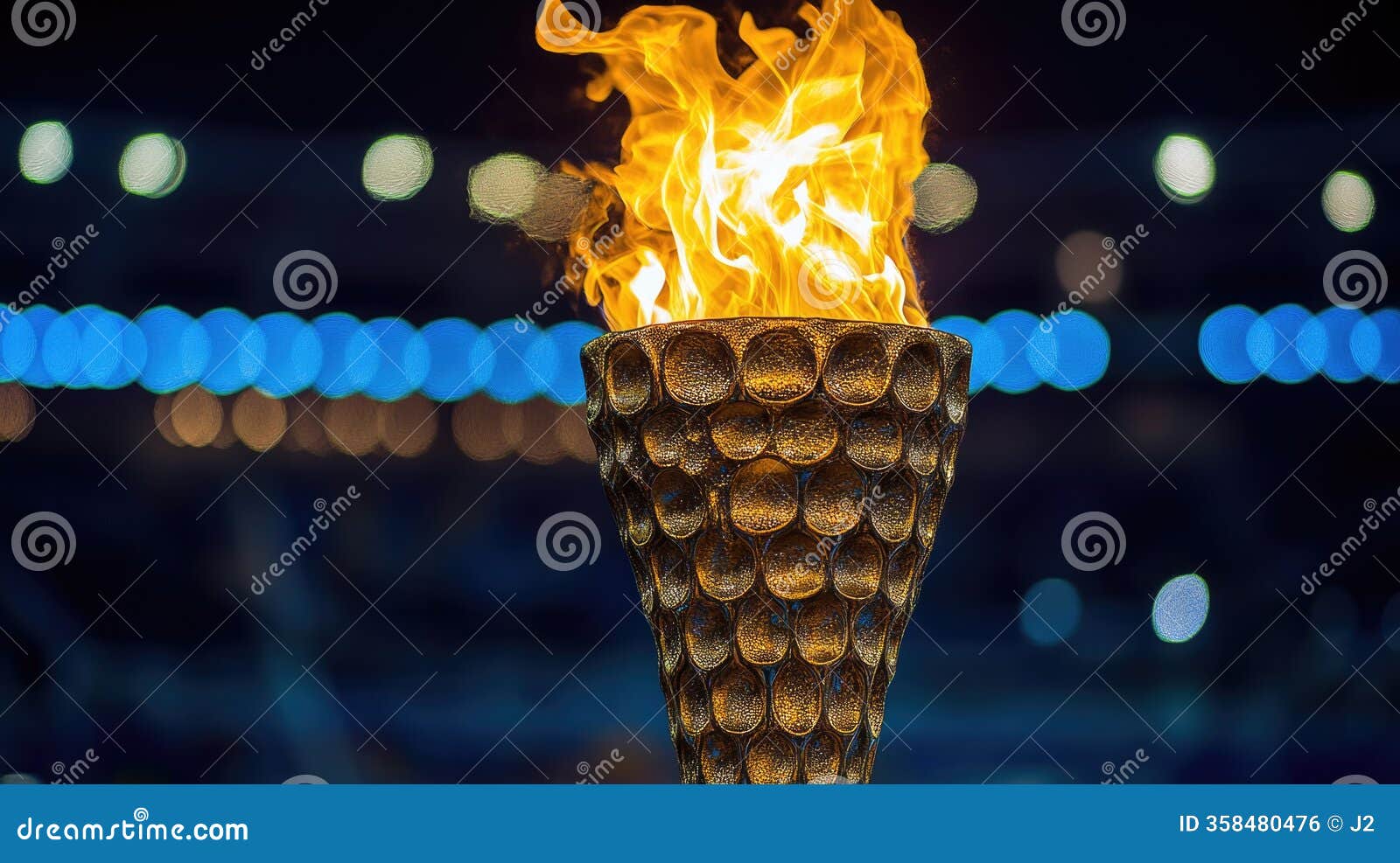 Olympic Torch with Flames at Night Stadium with Blurred Lights in ...