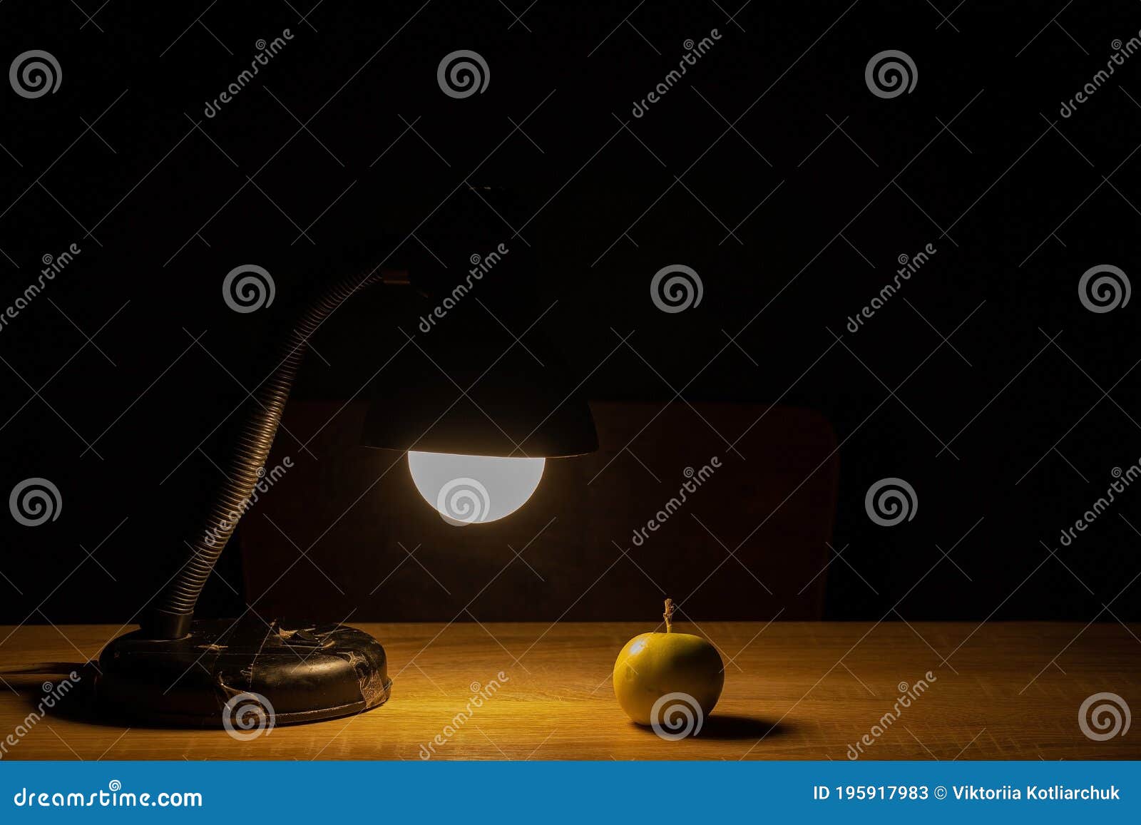 Apple on a Table in a Dark Room and a Table Lamp Illuminates the Table ...