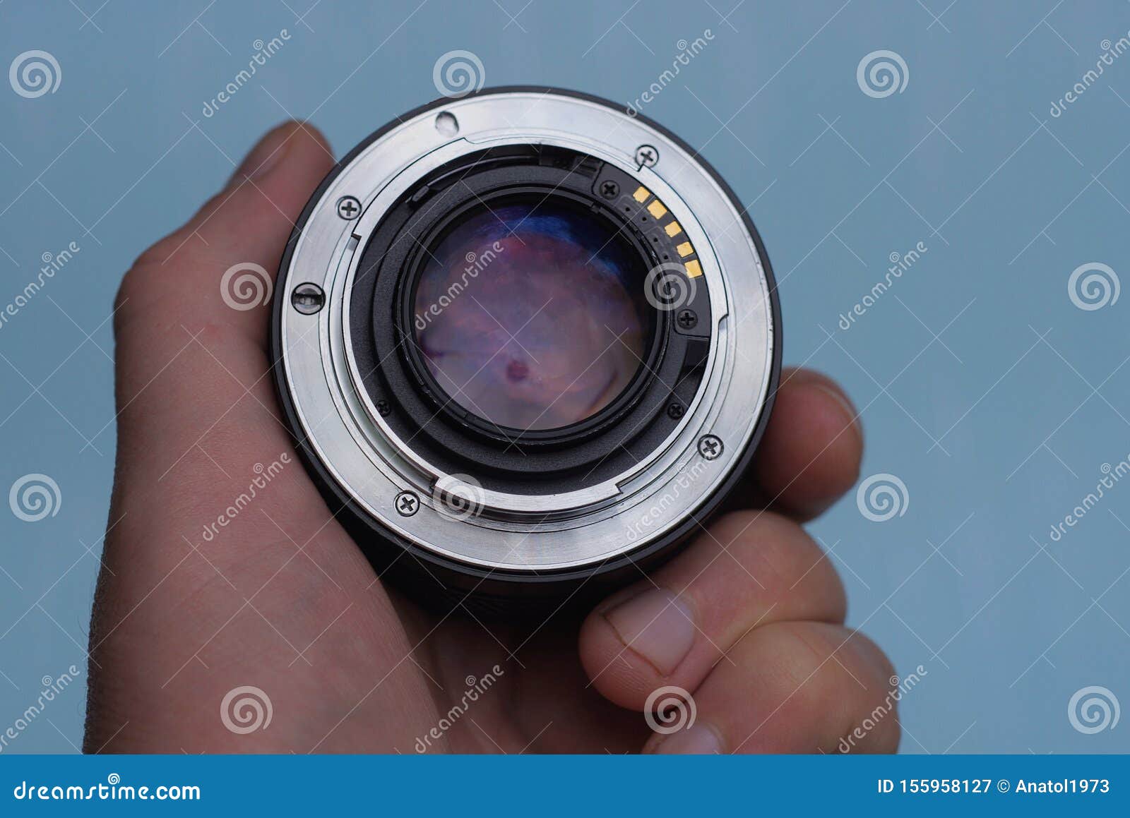 Open Camera Lens in a Hand on a Blue Background Stock Image - Image of ...