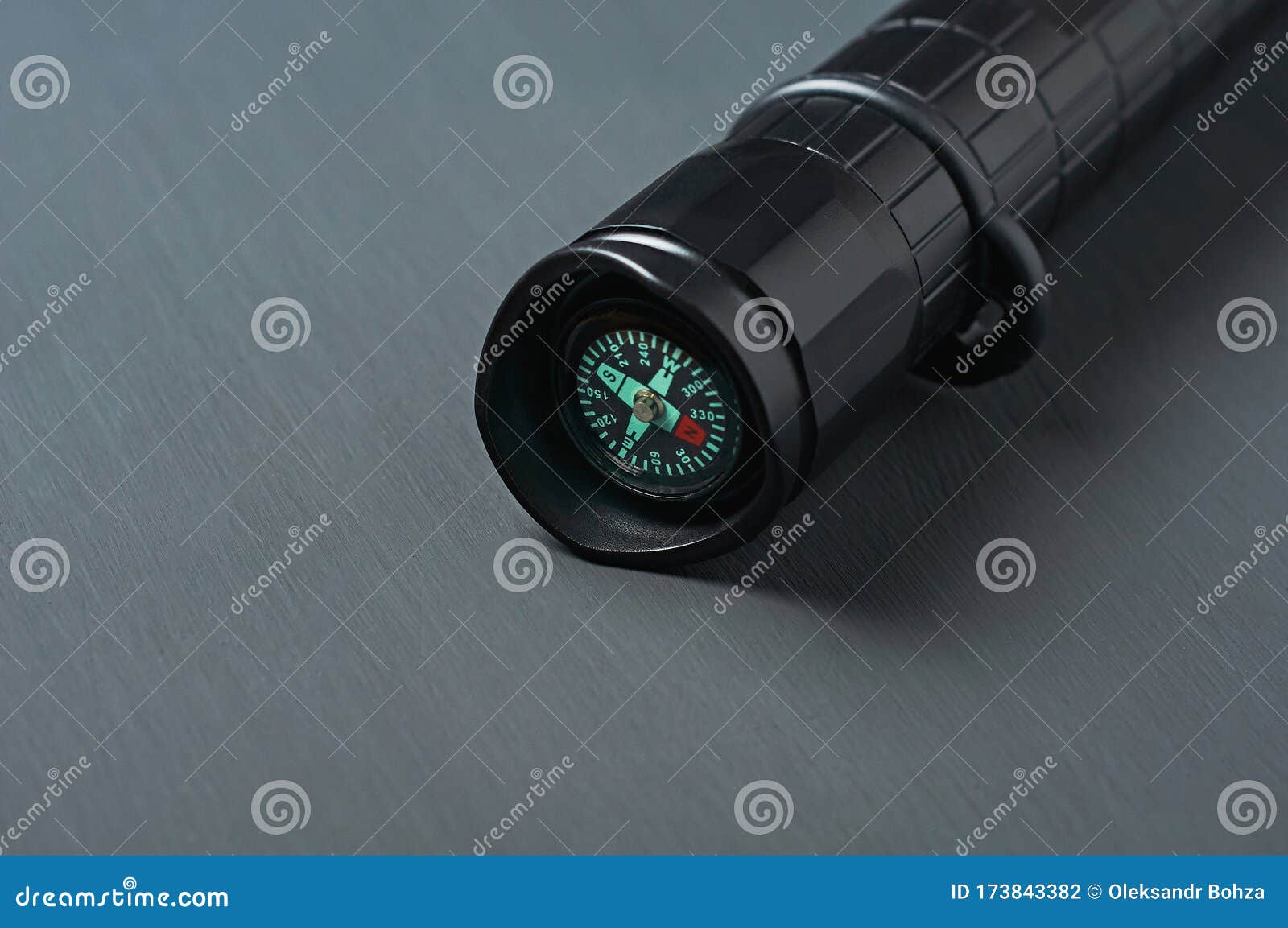One Black Tactical Flashlight with Compass for Survival Lies on Dark ...