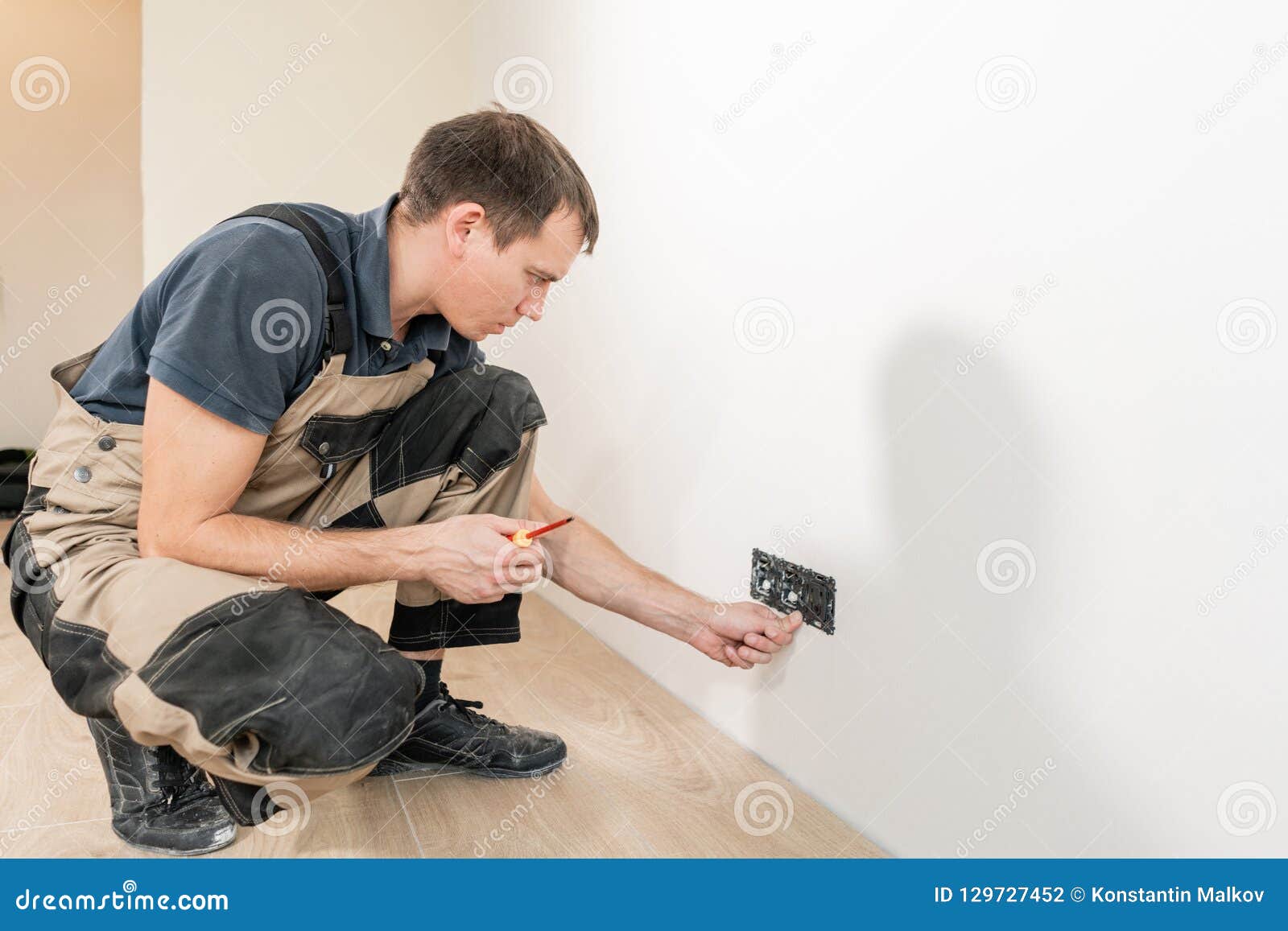 One Electrician Worker at Wiring Cable and Light Switch or Power Wall ...