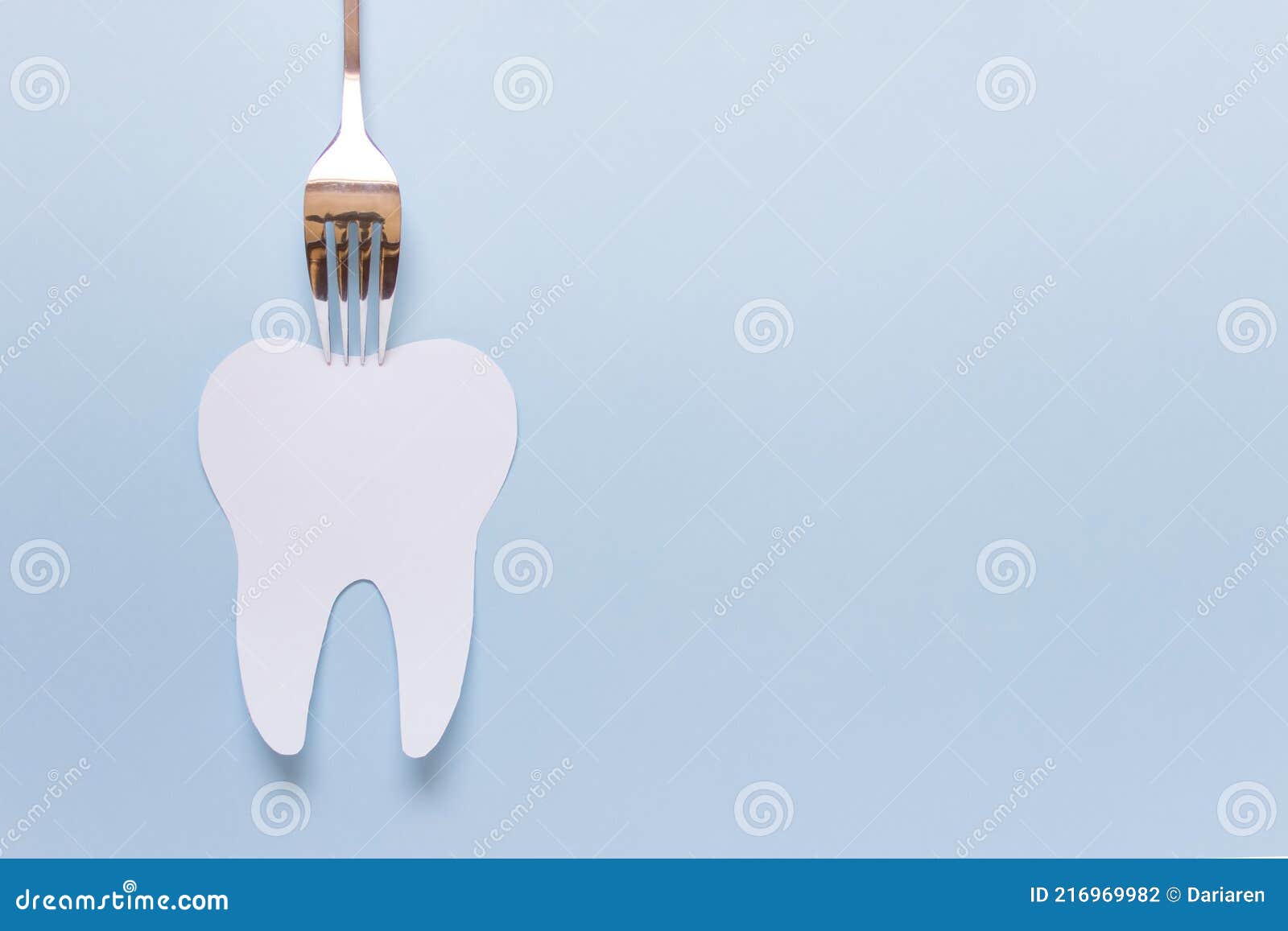 One Large Paper Tooth with Metallic Silver Fork on Blue Background ...