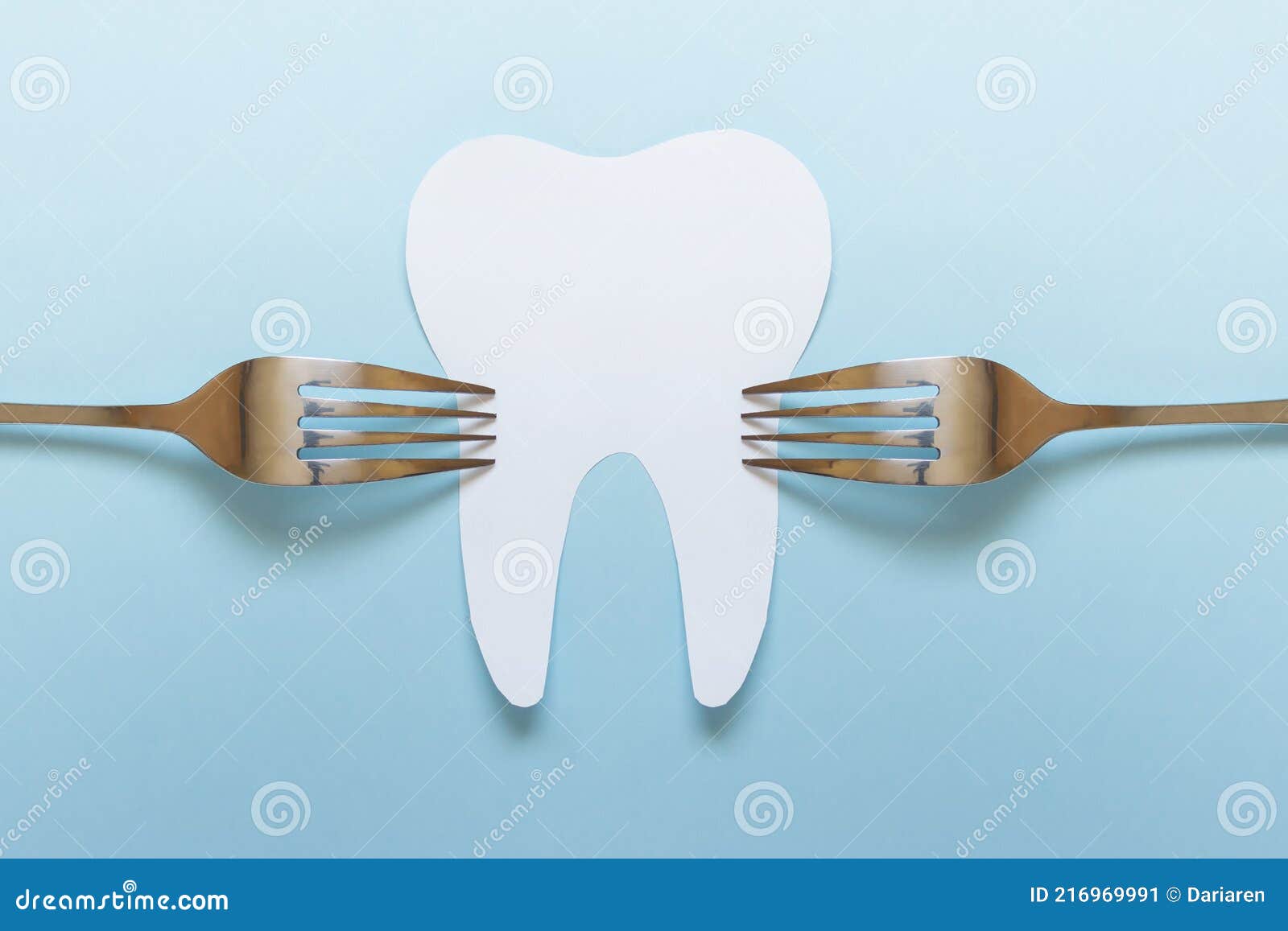 One Large Tooth with Two Metallic Forks on Blue Background Stock Image ...