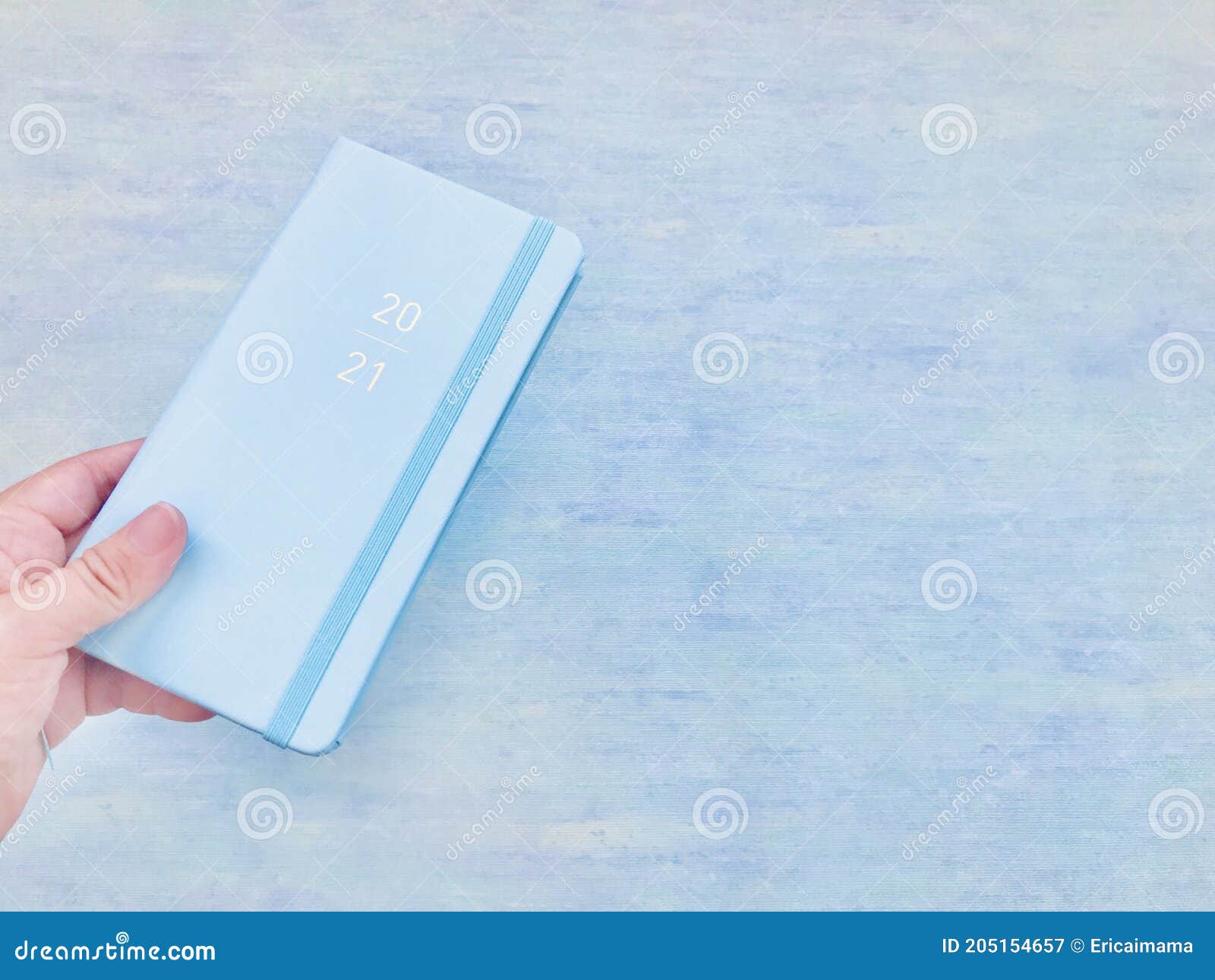 One Hand Is Holding A Light Blue 2021 Diary, Aqua Blue Background ...