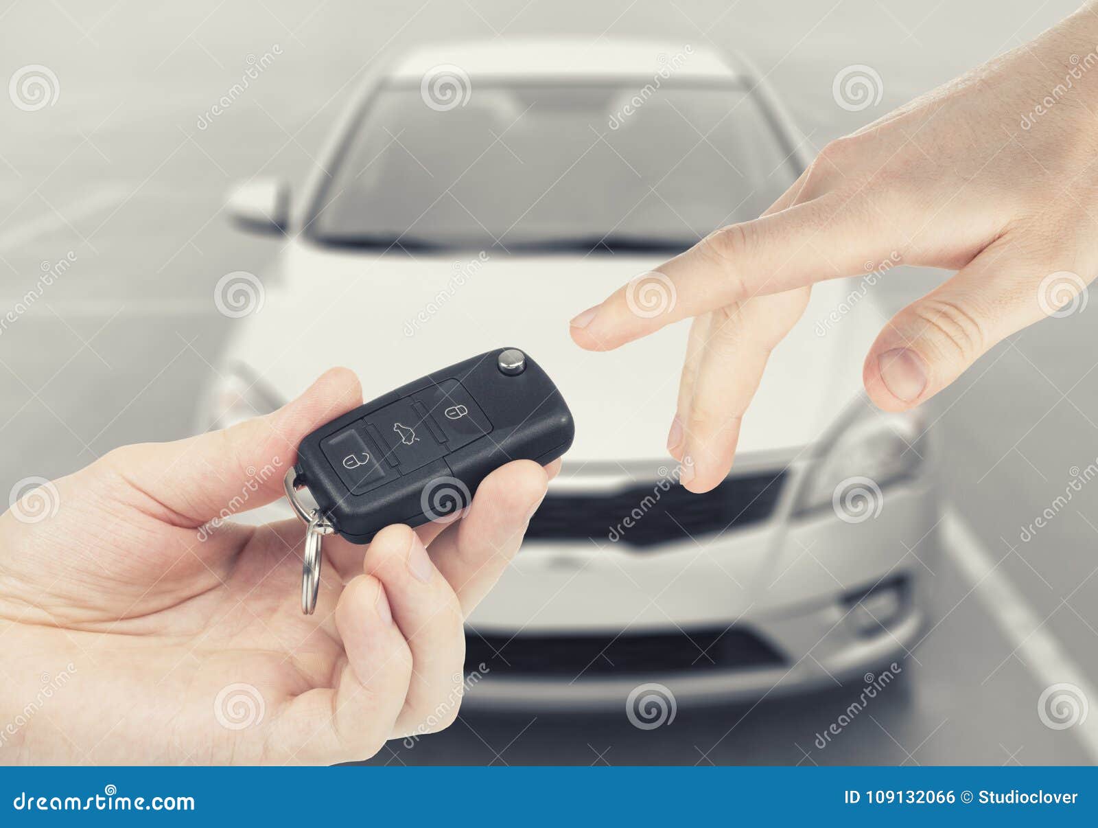 One Person Passing Car Keys To Another Person with Car on Background ...