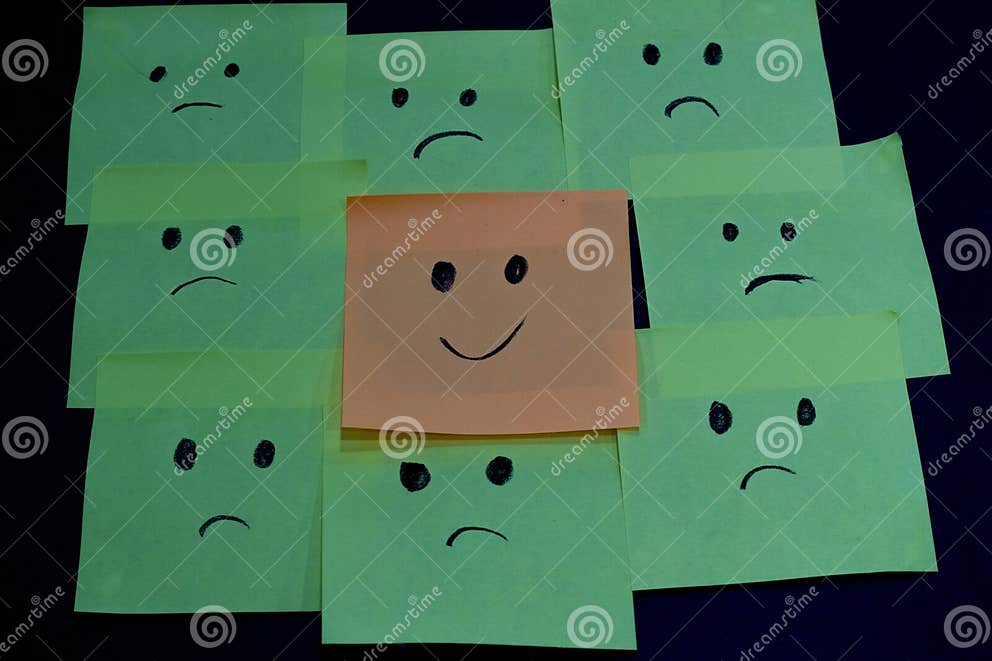 One Smiley Face Amongst All the Sad Faces Drawn on Sticky Notes Stock ...
