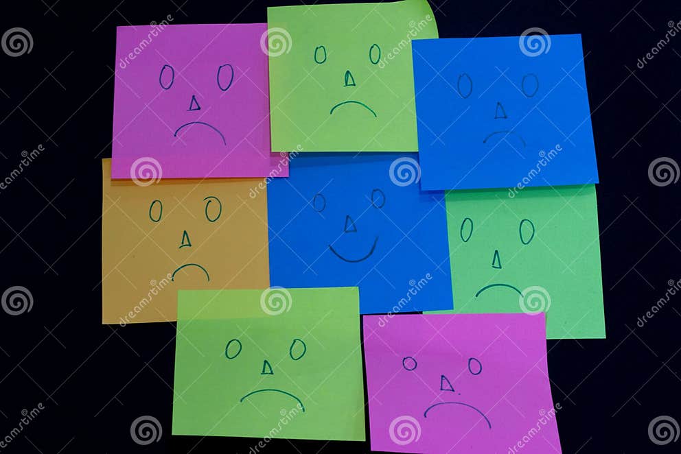 One Smiley Face Amongst All the Sad Faces Drawn on Sticky Notes Stock ...