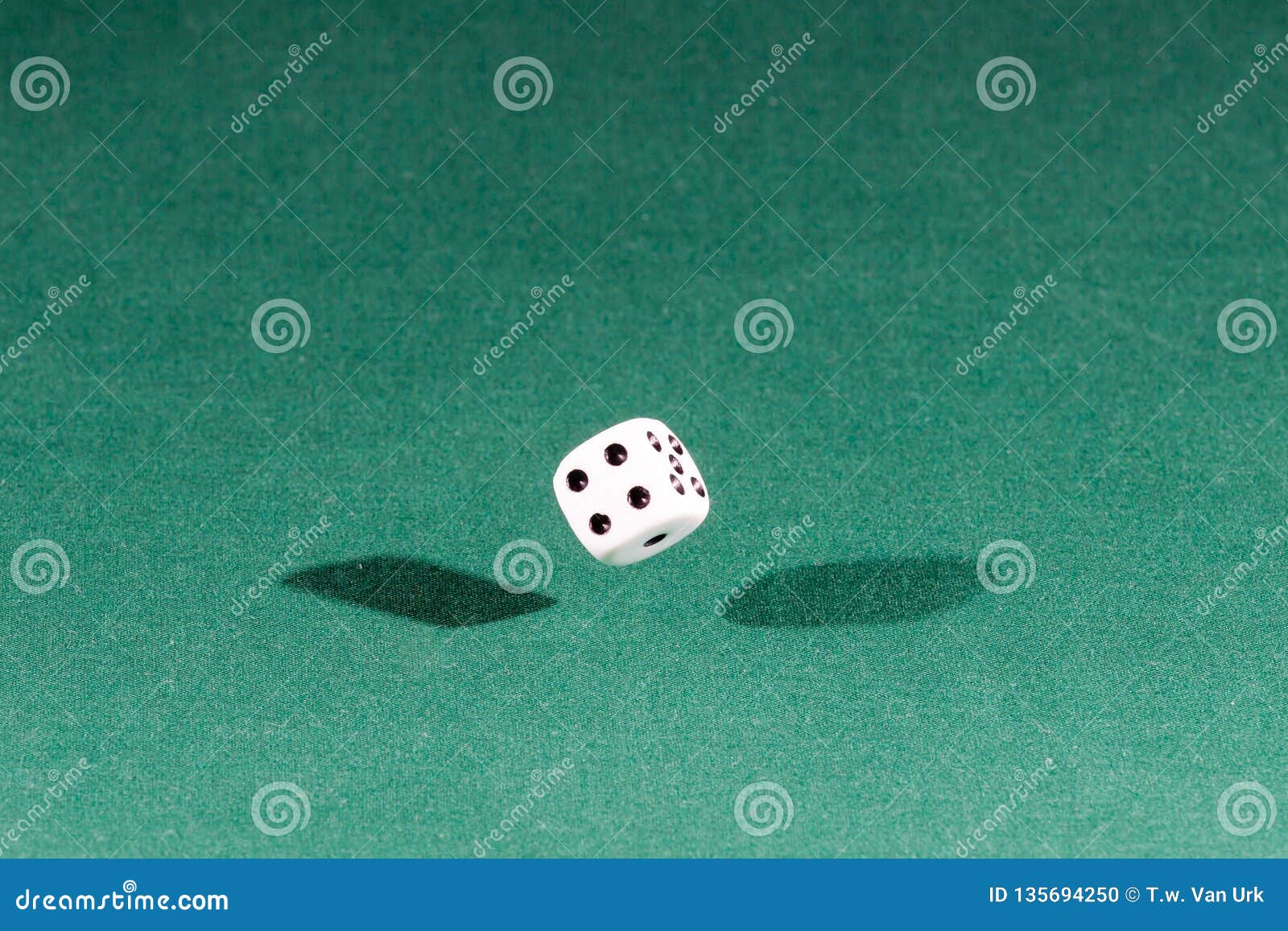 One White Dice Falling on a Green Table Stock Photo - Image of ...