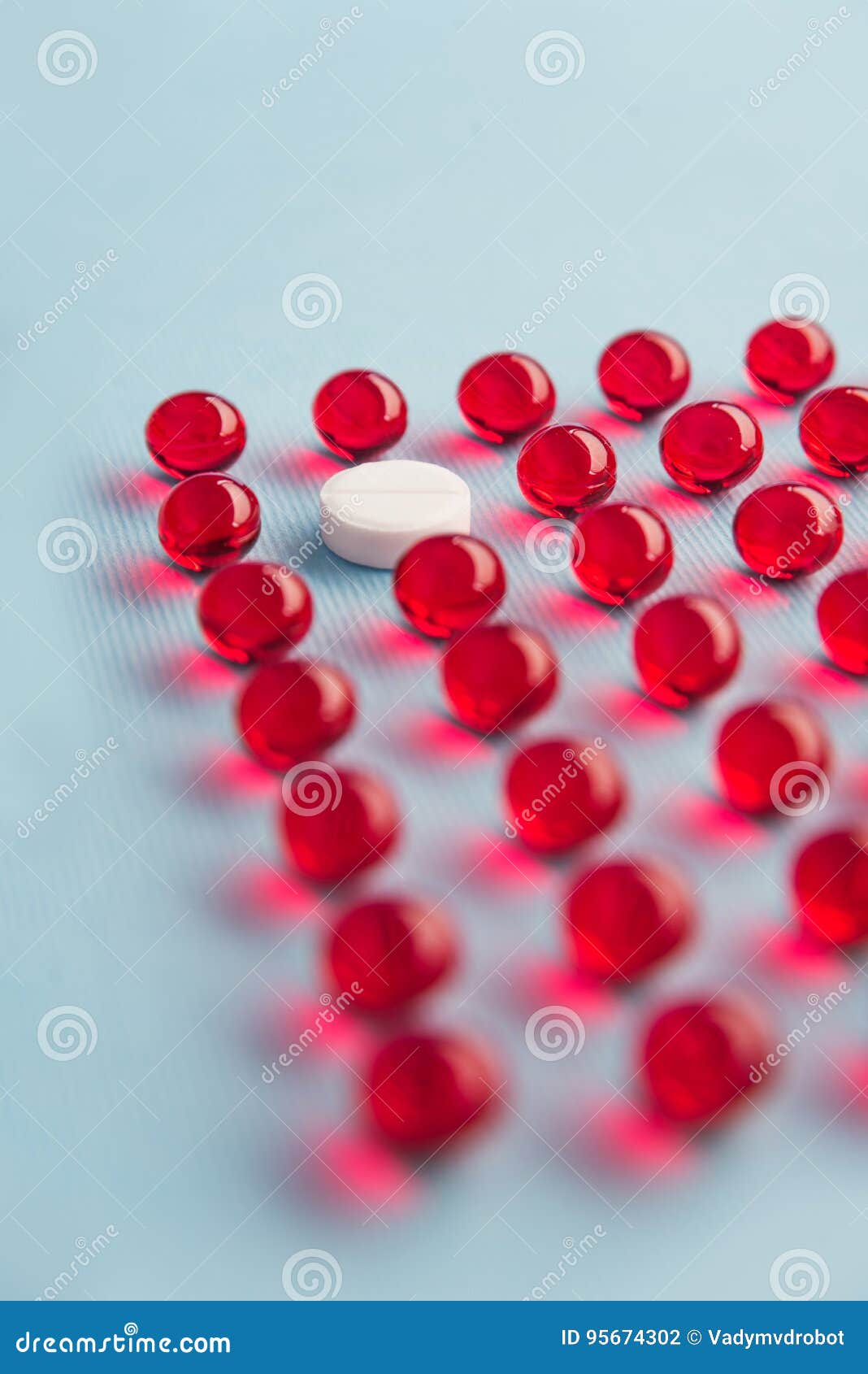 One White Round Tablet in a Grid of Red Capsules Stock Photo - Image of ...