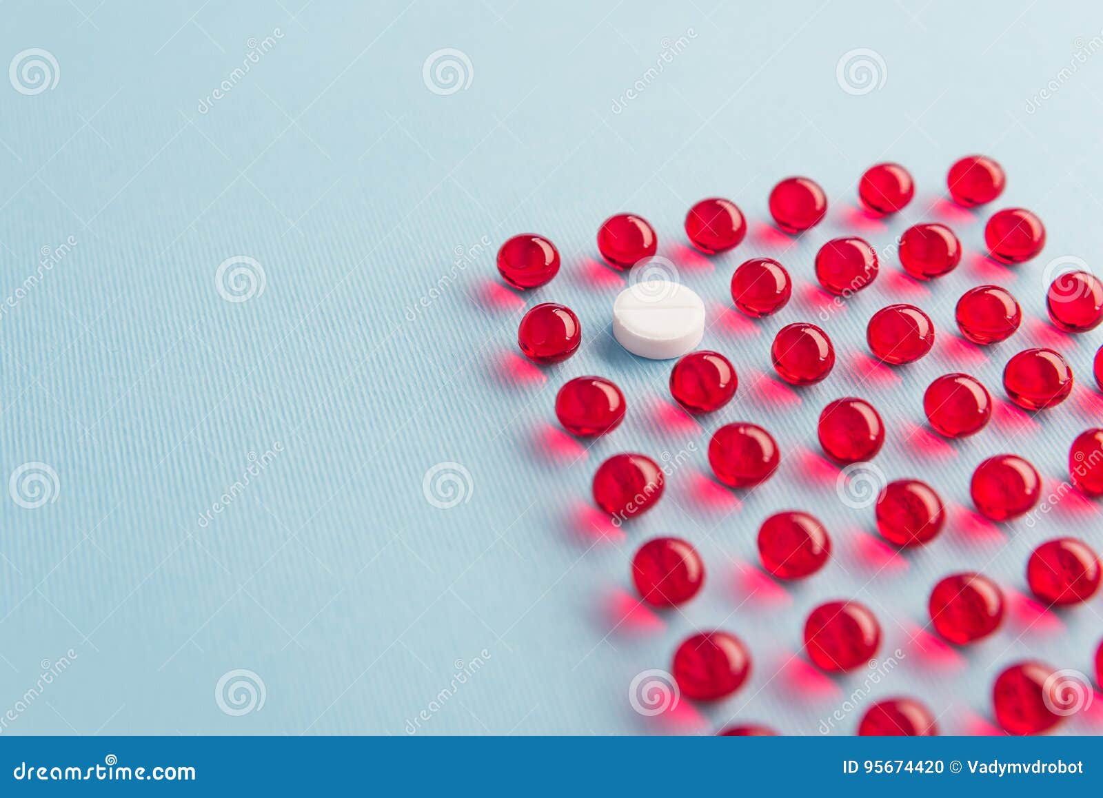 One White Round Tablet in a Grid of Red Capsules Stock Photo - Image of ...