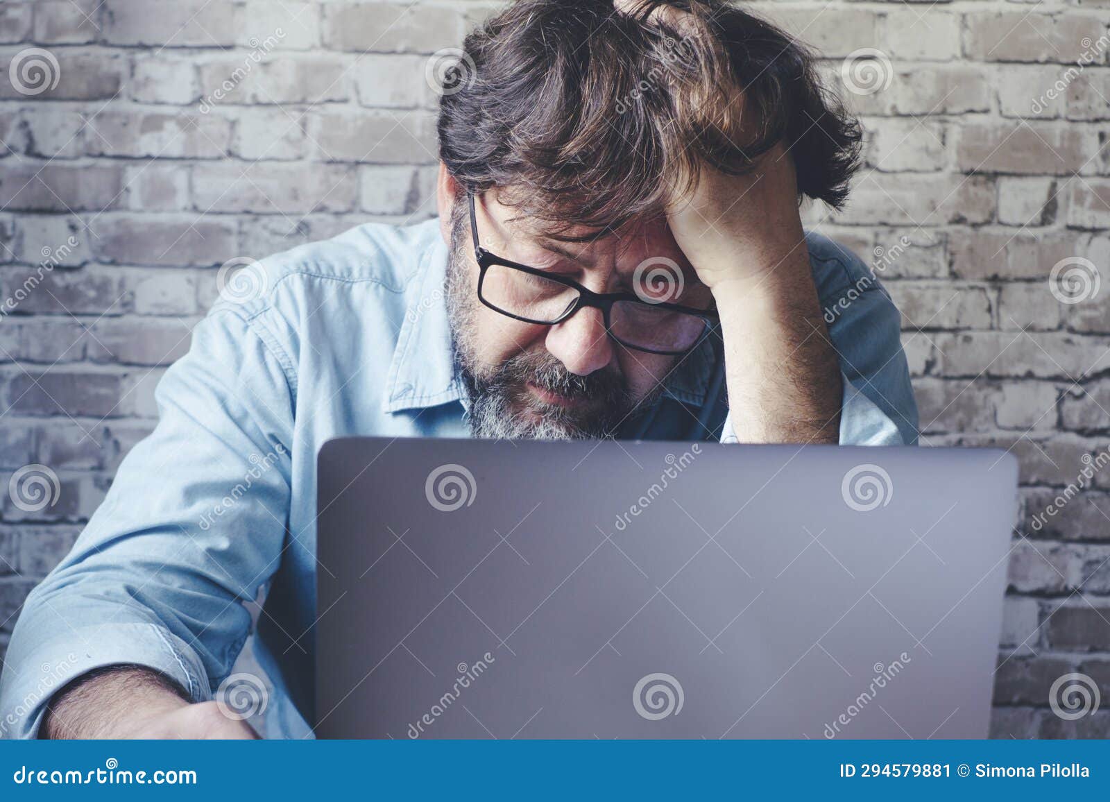 One Worried Man in Front of a Laptop with Hand on His Head Looking the ...