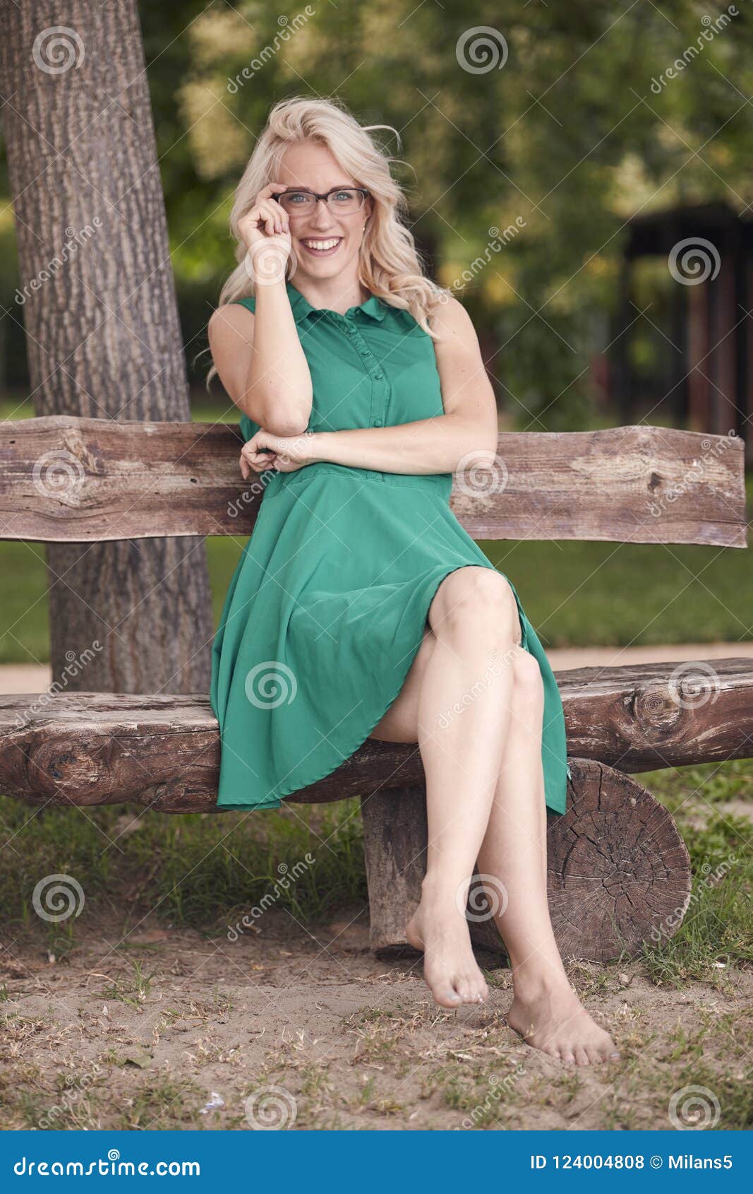 One Young Woman 25 Years Old Sitting In Wood Bench In Park Green