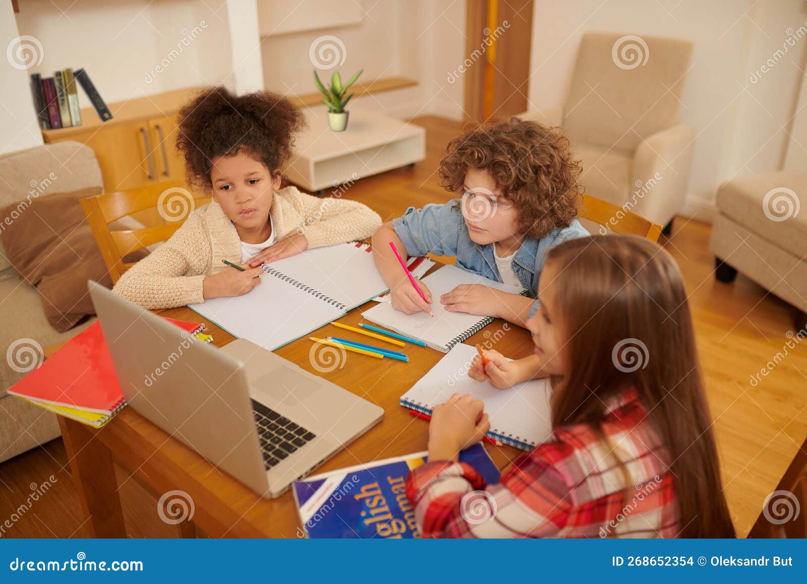 A Group of Kids Studying Remotely Together and Writing Something Down ...