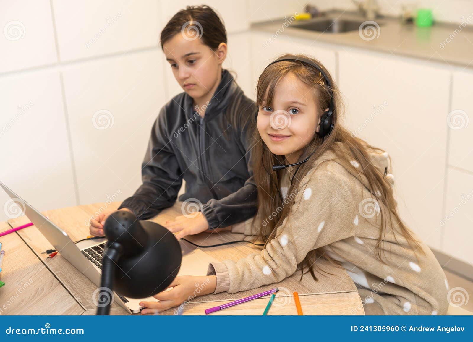 Online Training. Two Schoolgirl Sisters in Headphones Listen To Lessons ... Online Training. Two Schoolgirl Sisters in Headphones Listen To Lessons ...