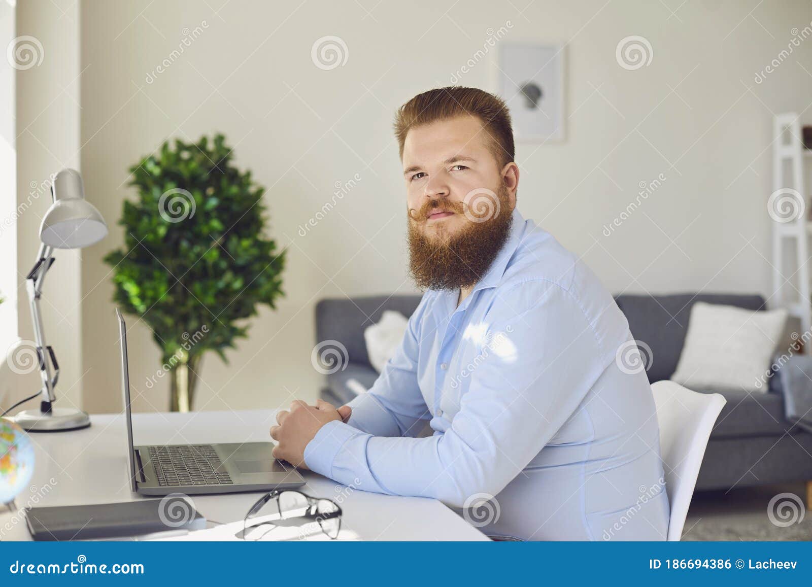Online Work at Home. a Serious Fat Bearded Man is Looking at the Camera ...