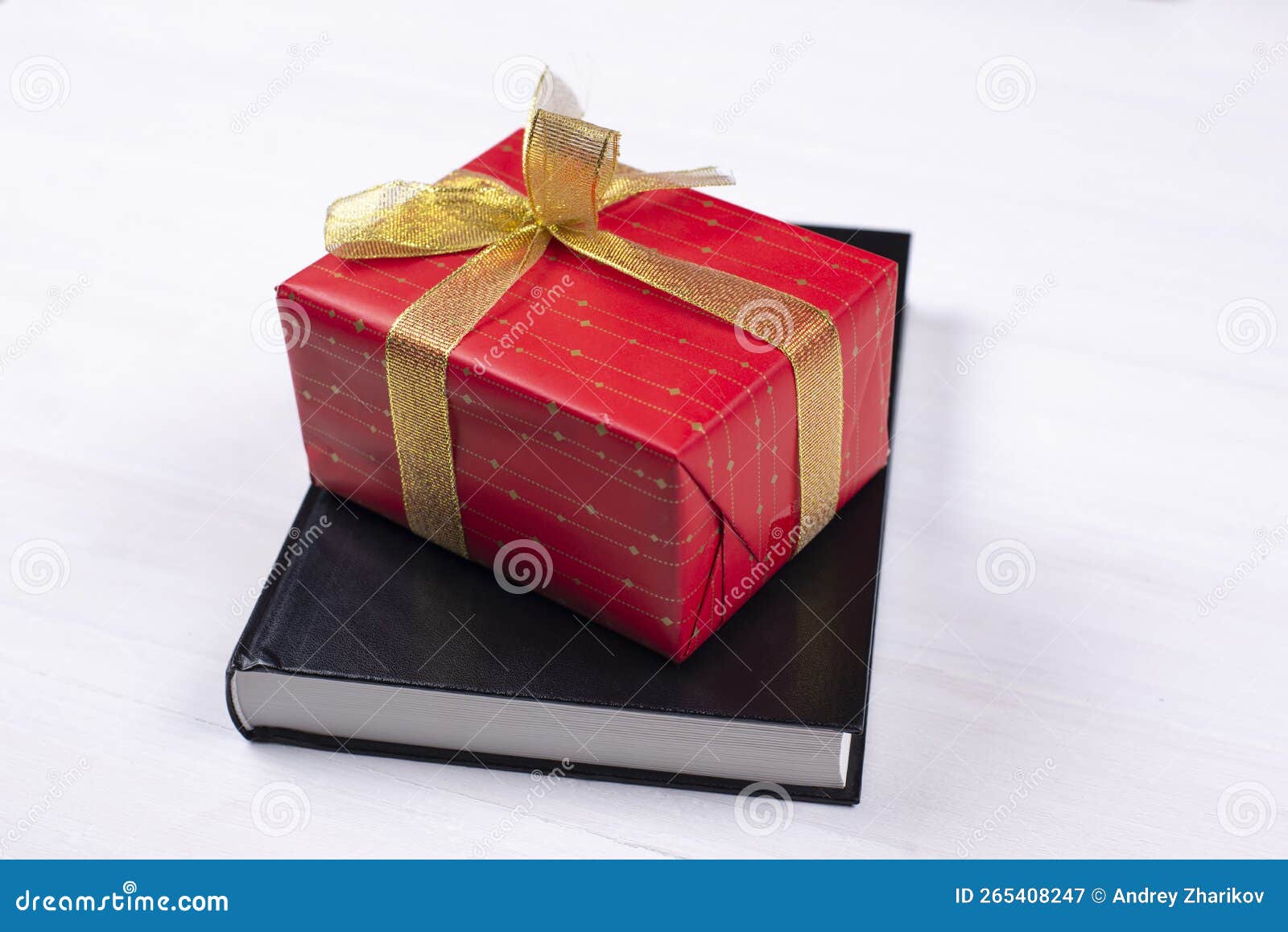 An Open Bible on the Table. a Gift on a Book. a Red Gift-wrapped Box ...