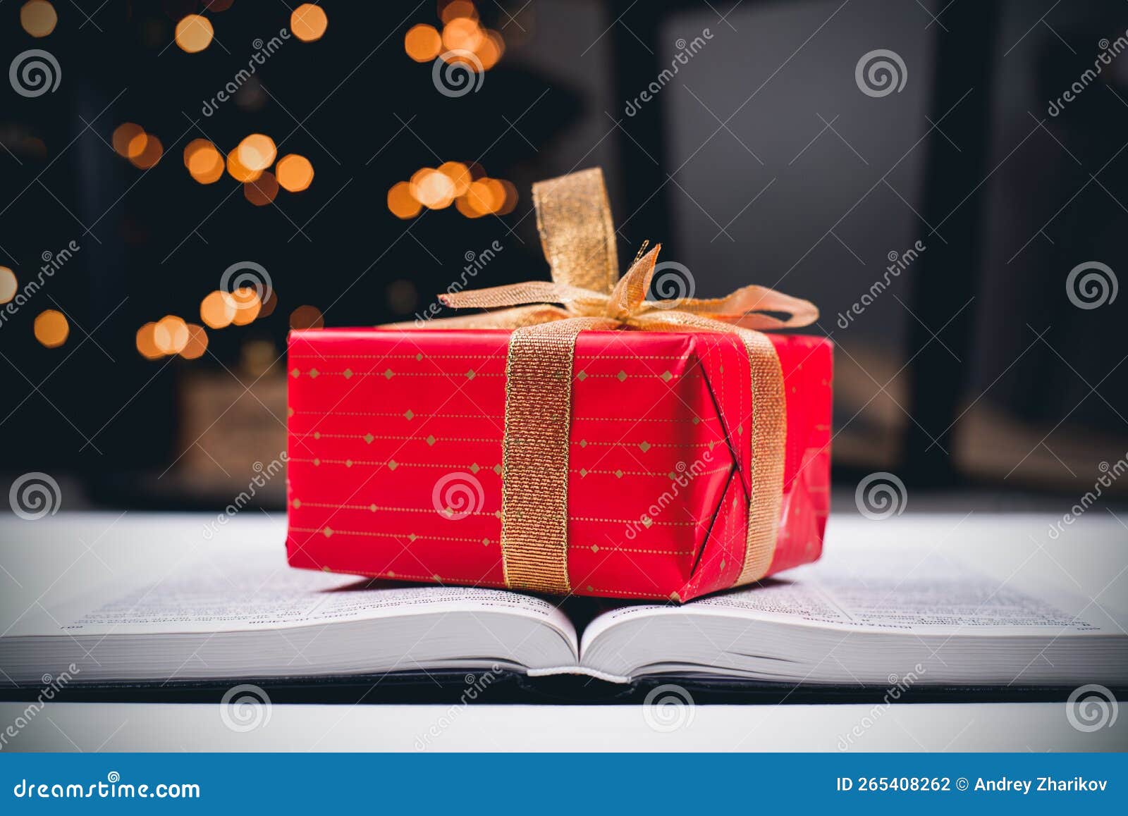 An Open Bible on the Table. a Gift on a Book. a Red Gift-wrapped Box ...