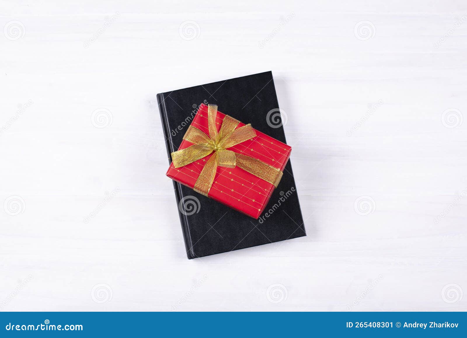 An Open Bible on the Table. a Gift on a Book. a Red Gift-wrapped Box ...