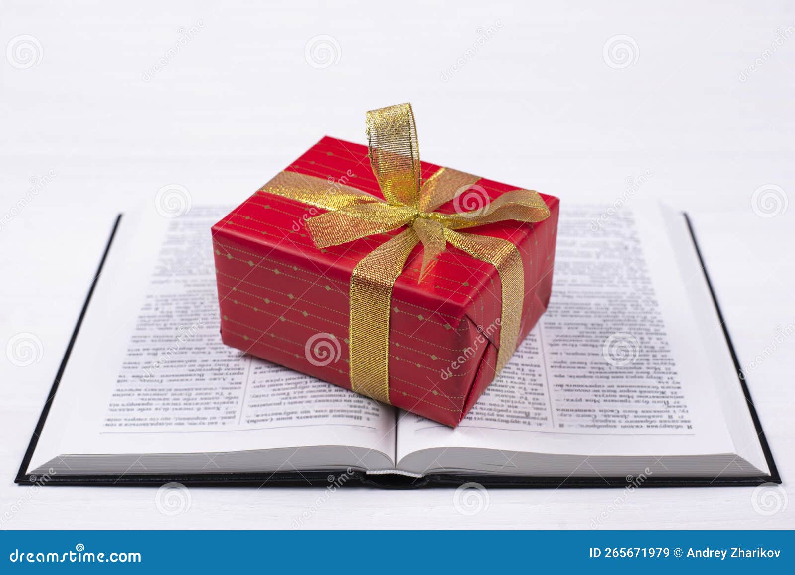 An Open Bible on the Table. a Gift on a Book. a Red Gift-wrapped Box ...