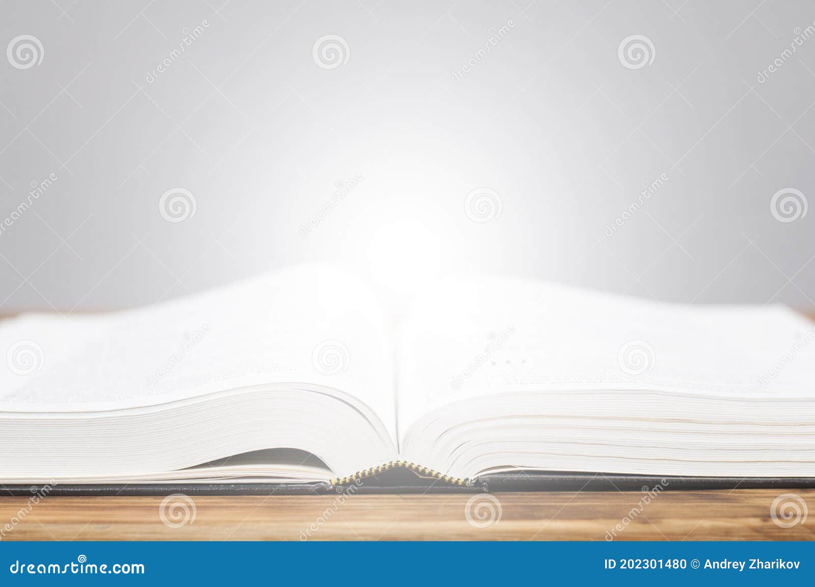 Open Big Book Bible on a Wooden Table. Light from a Book. Close-up ...