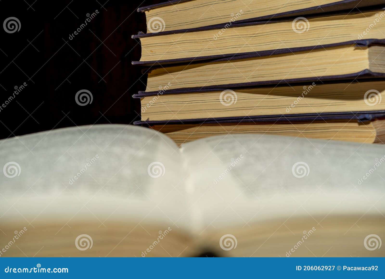 An Open Book on the Background of a Stack of Books. Reading a Book ...
