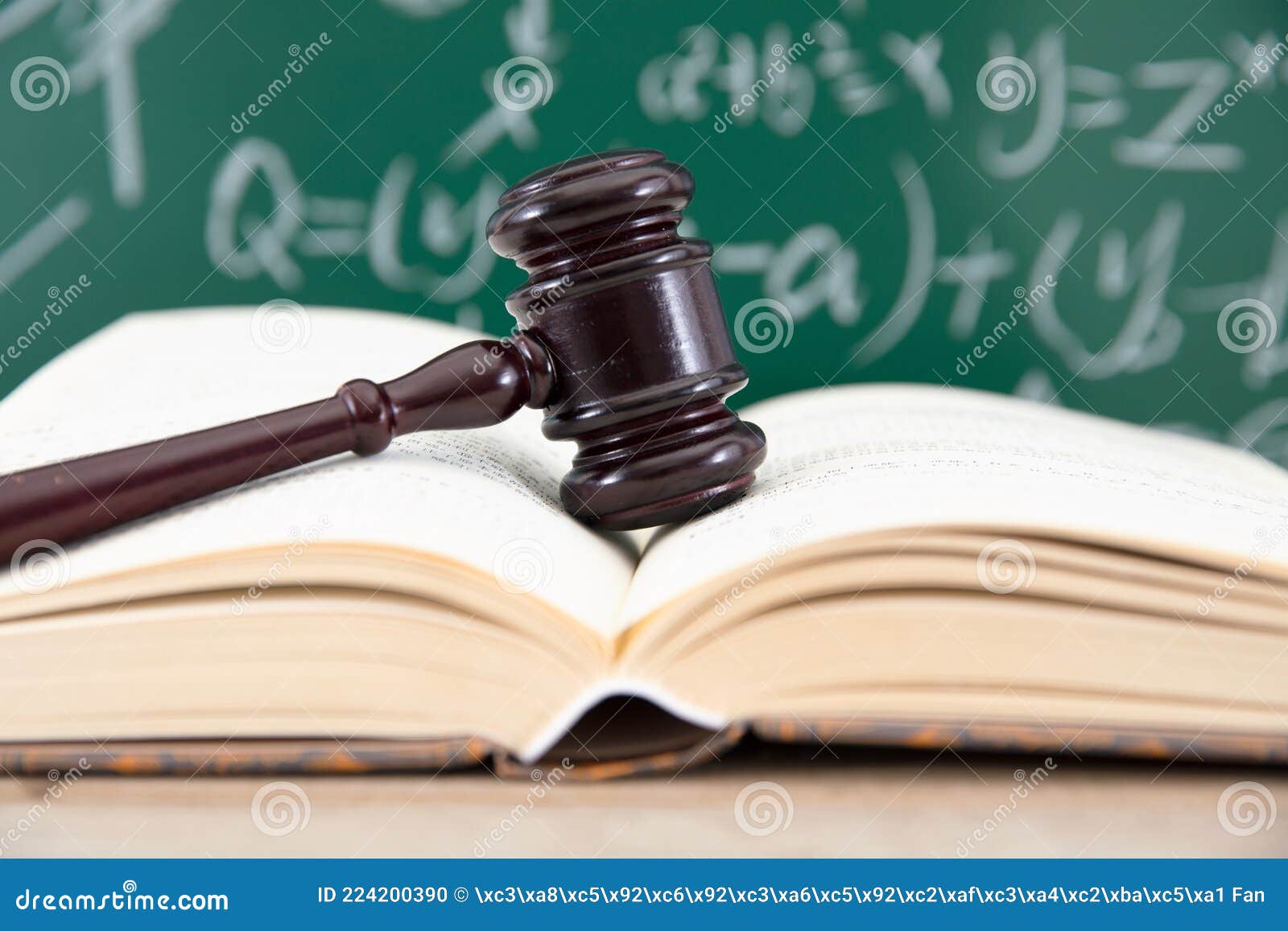 An Open Book in Front of the Blackboard and a Hammer on the Book Stock ...