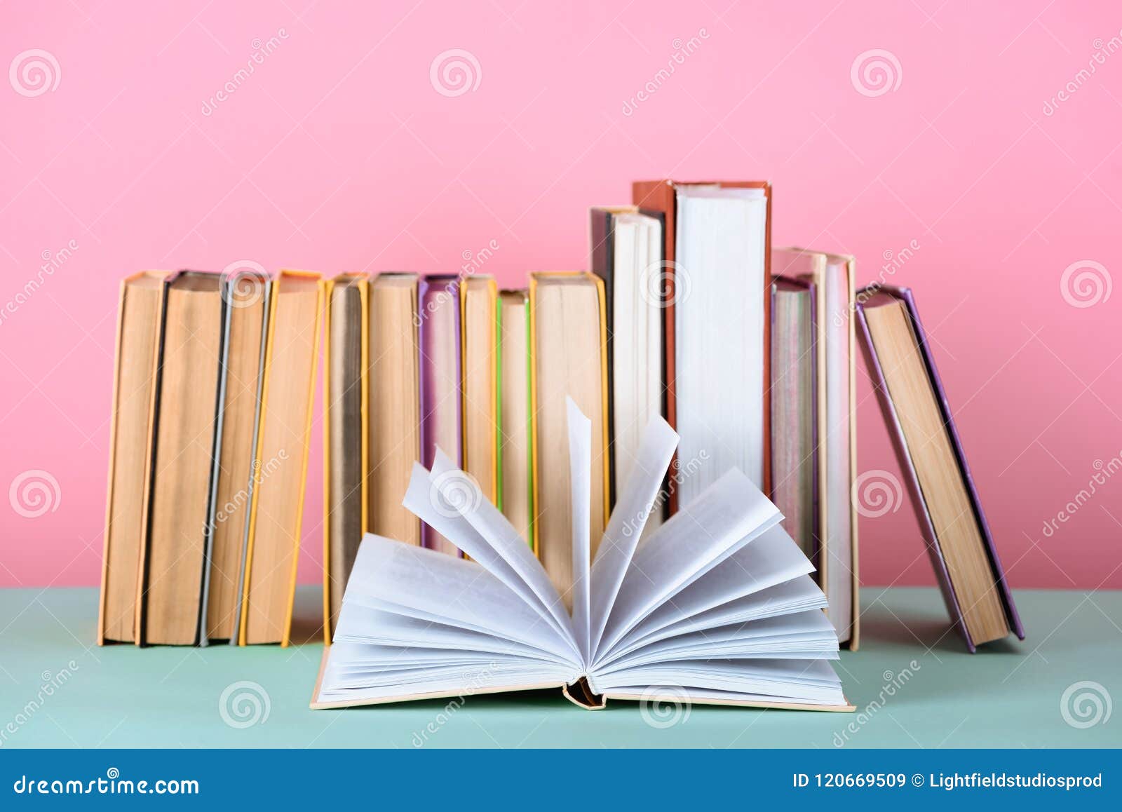 Open Book in Front of Row of Books on Table Stock Image - Image of ...