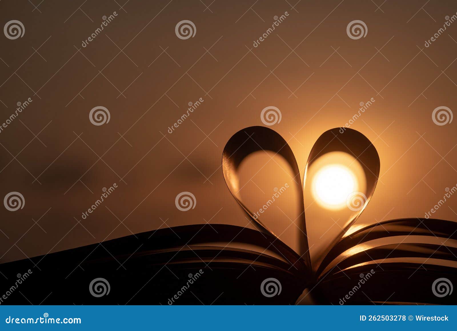 Open Book with Heart-shaped Pages Against a Beautiful Sunset Stock ...