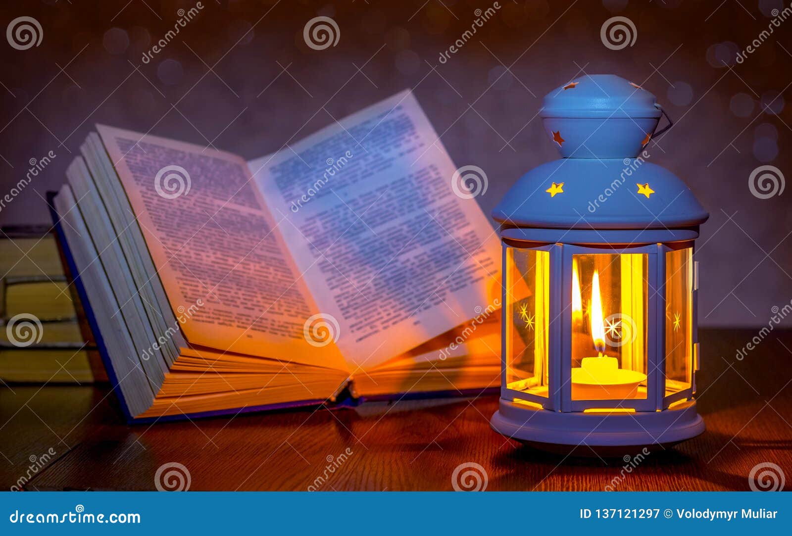 An Open Book Illuminated by a Light of a Lantern. Lantern with a Candle ...
