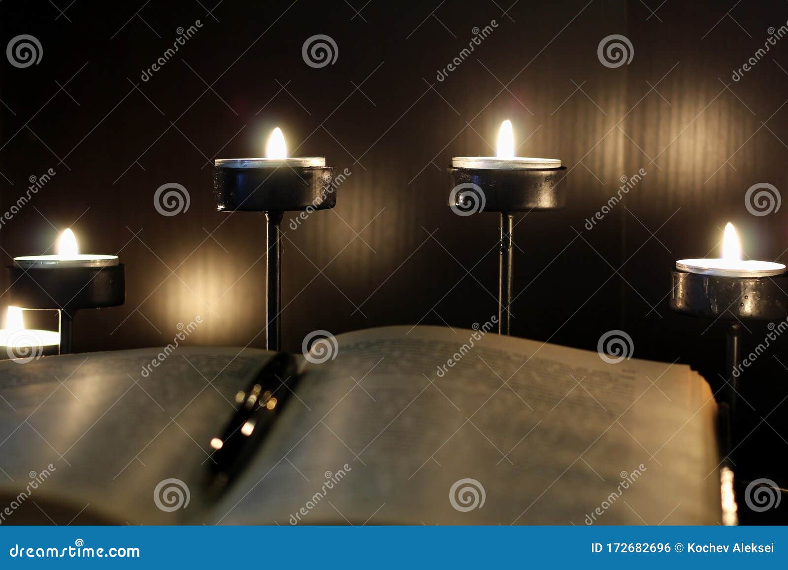 An Open Book in the Light of Burning Candles. a Dark and Cozy ...