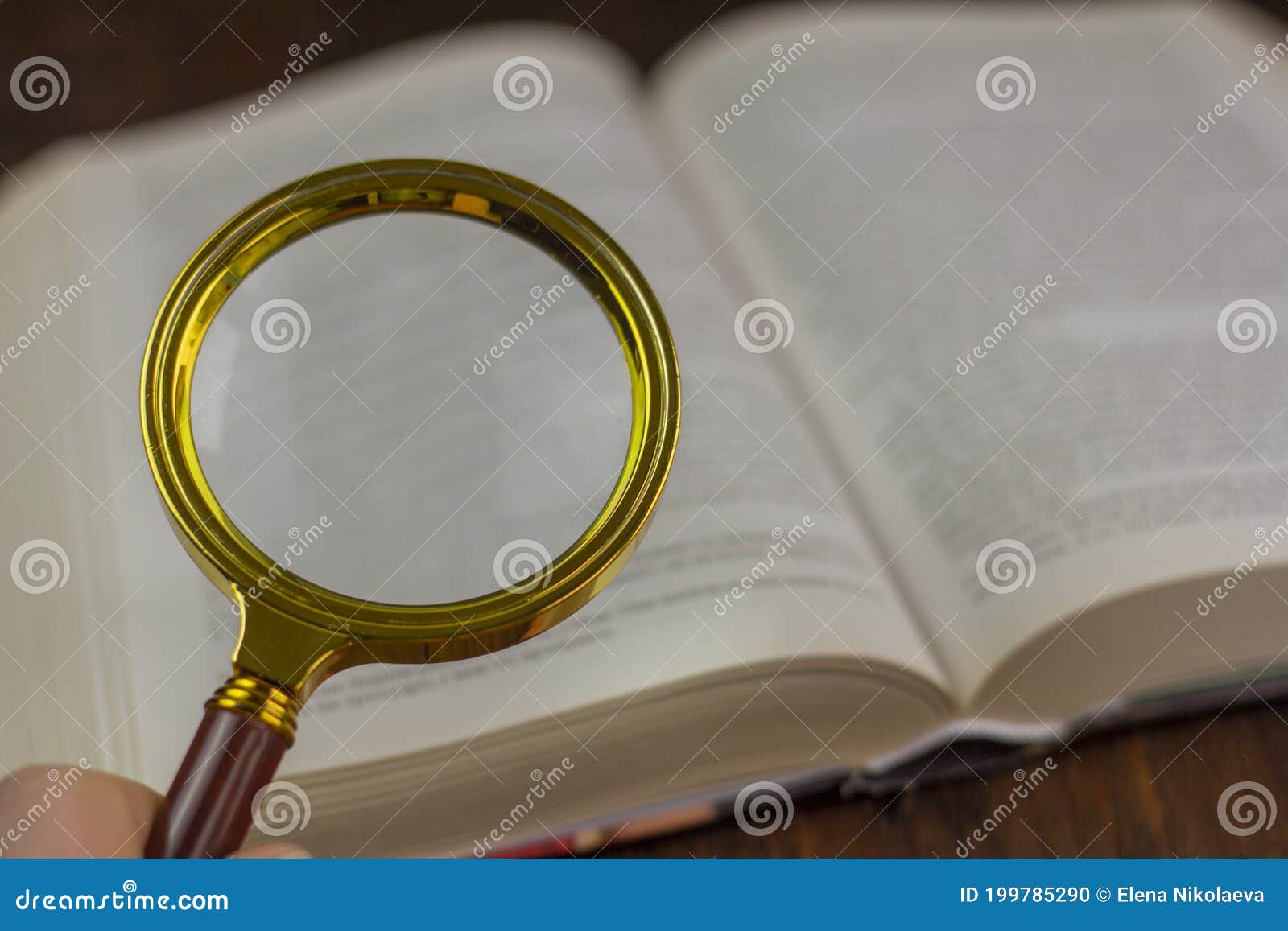 Open Book and Magnifying Glass in Hand Close-up.Retrieval Stock Photo ...