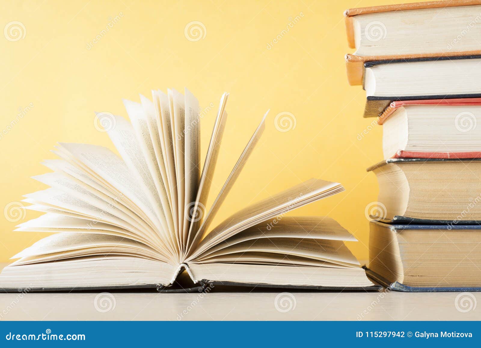 Open Book and Stack of Books on Wooden Table. Education Background ...