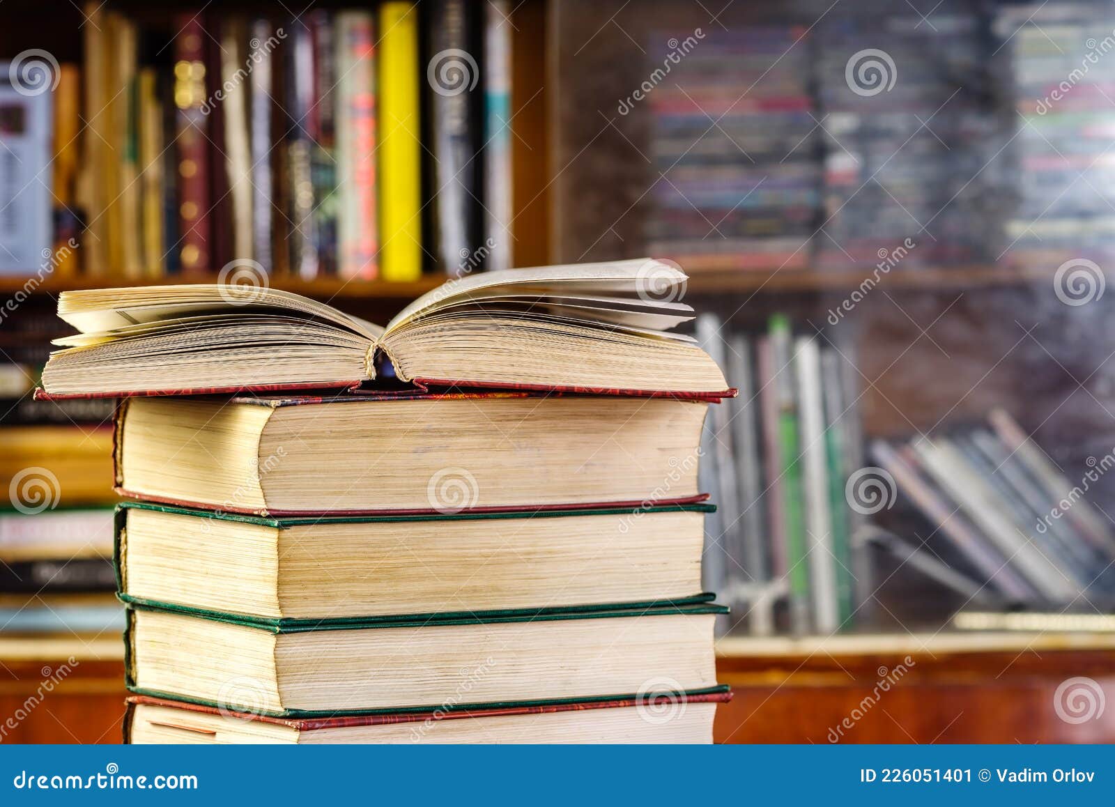An Open Book on a Stack in Front of a Bookcase Stock Image - Image of ...