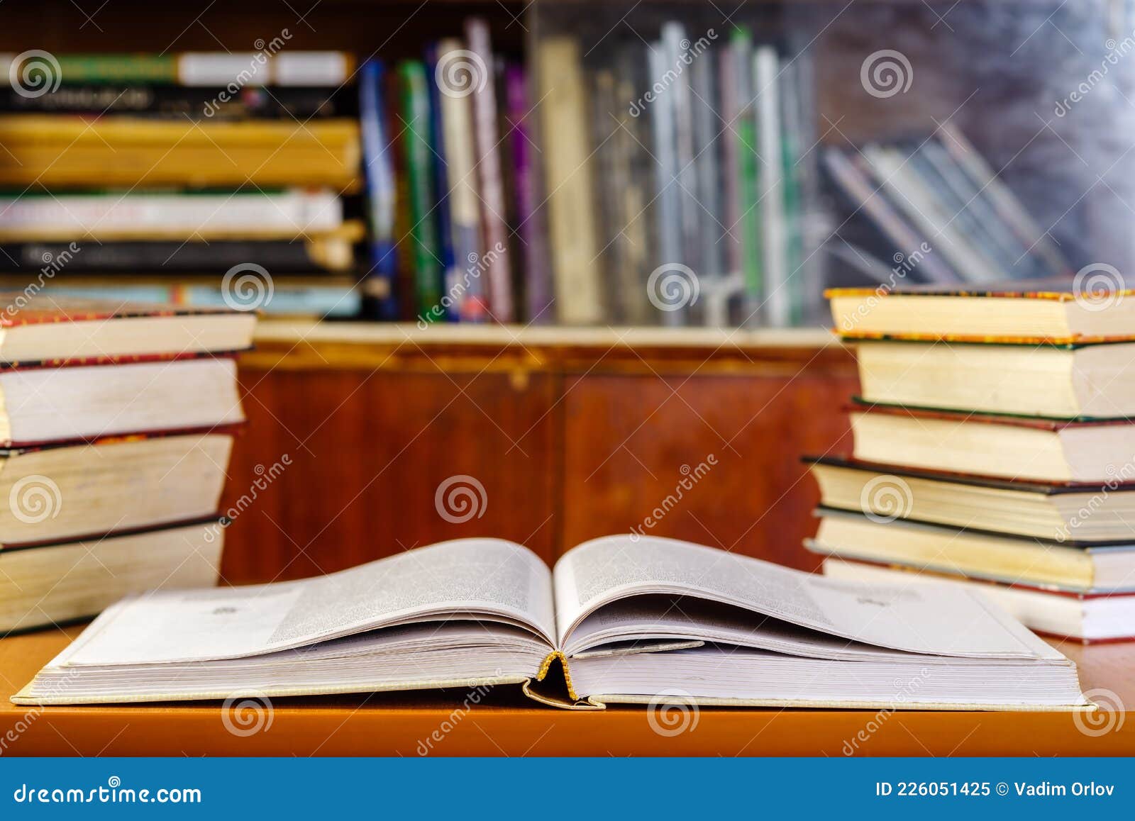 An Open Book on the Table in Front of the Bookcase Stock Image - Image ...