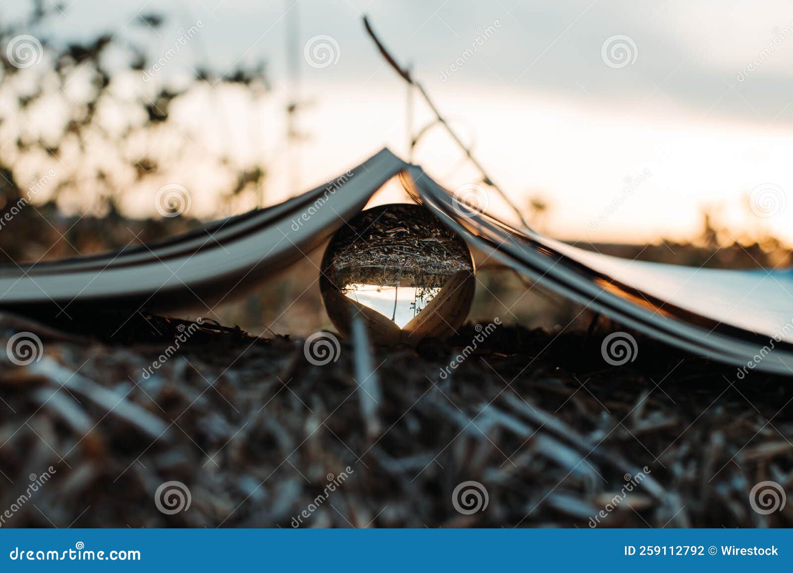 Open Book Upside Down Over a Glass Ball Reflecting a Landscape Stock ...