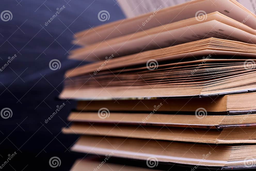 Open Books are a Stack on the Desk, Against the Background of a Chalk ...