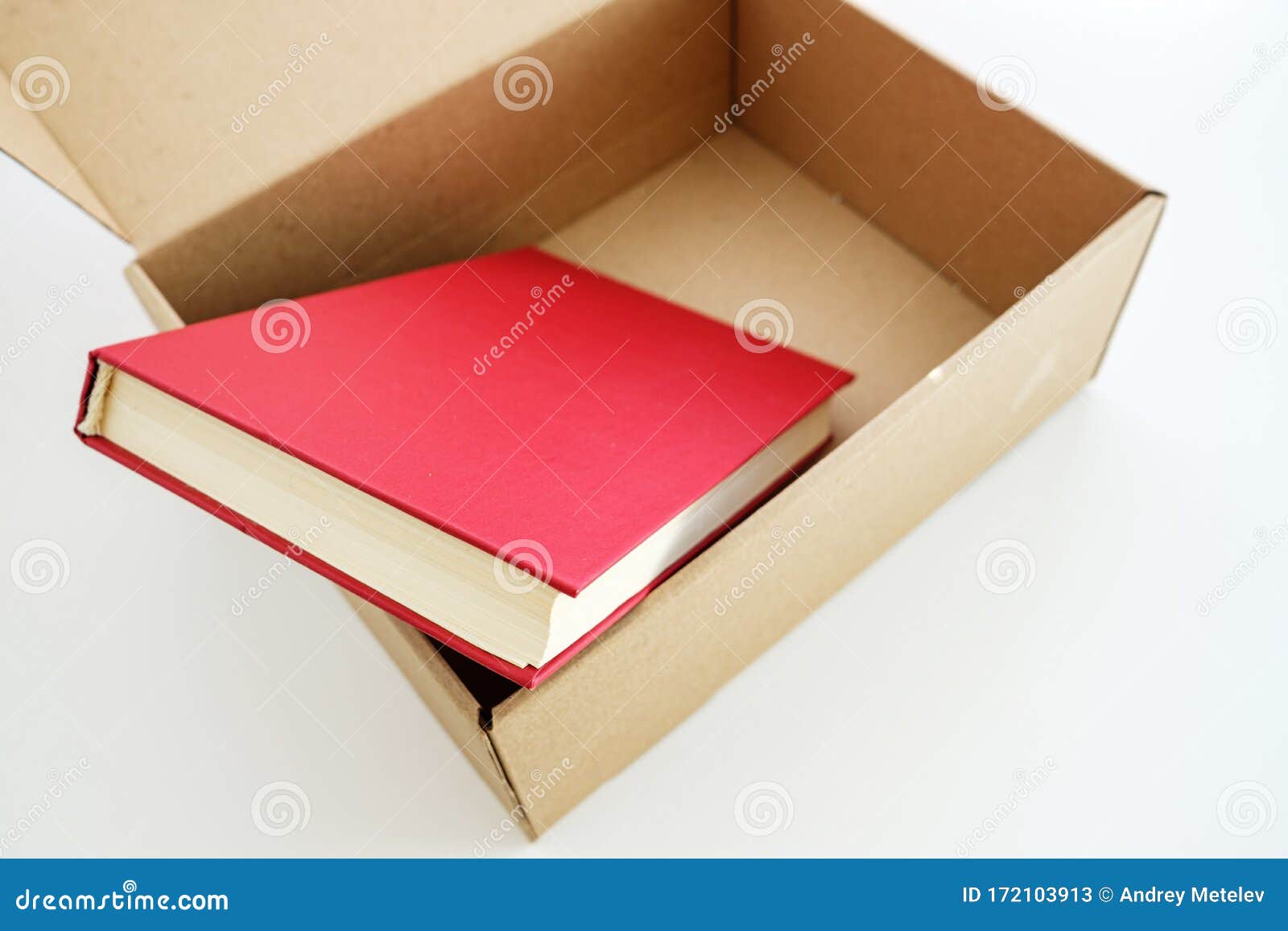In an Open Box, a Book Sticks Out from Under the Parcel Stock Image ...