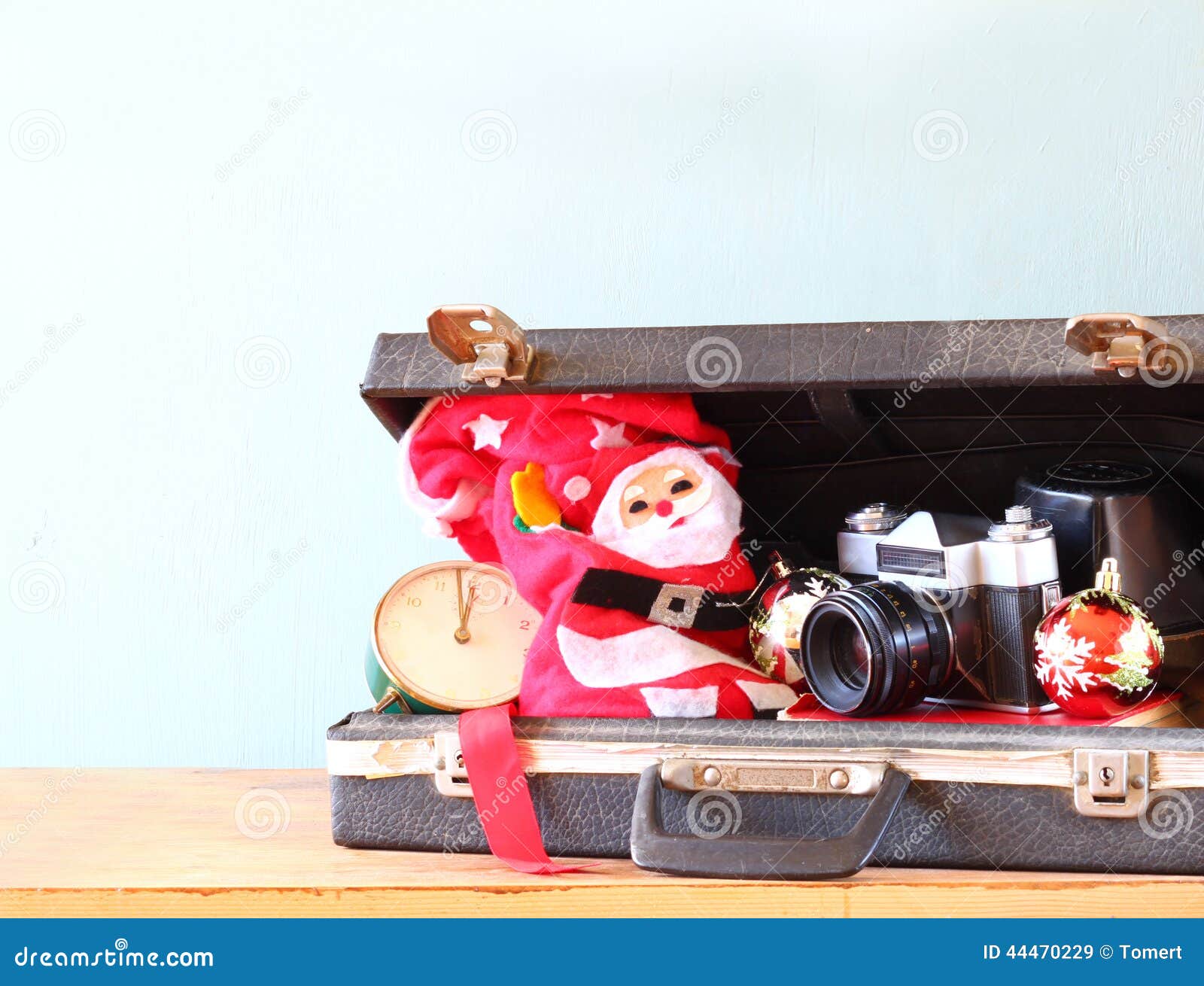 Open Briefcase with Christmas Decorations and Camera in Front of Beach ...