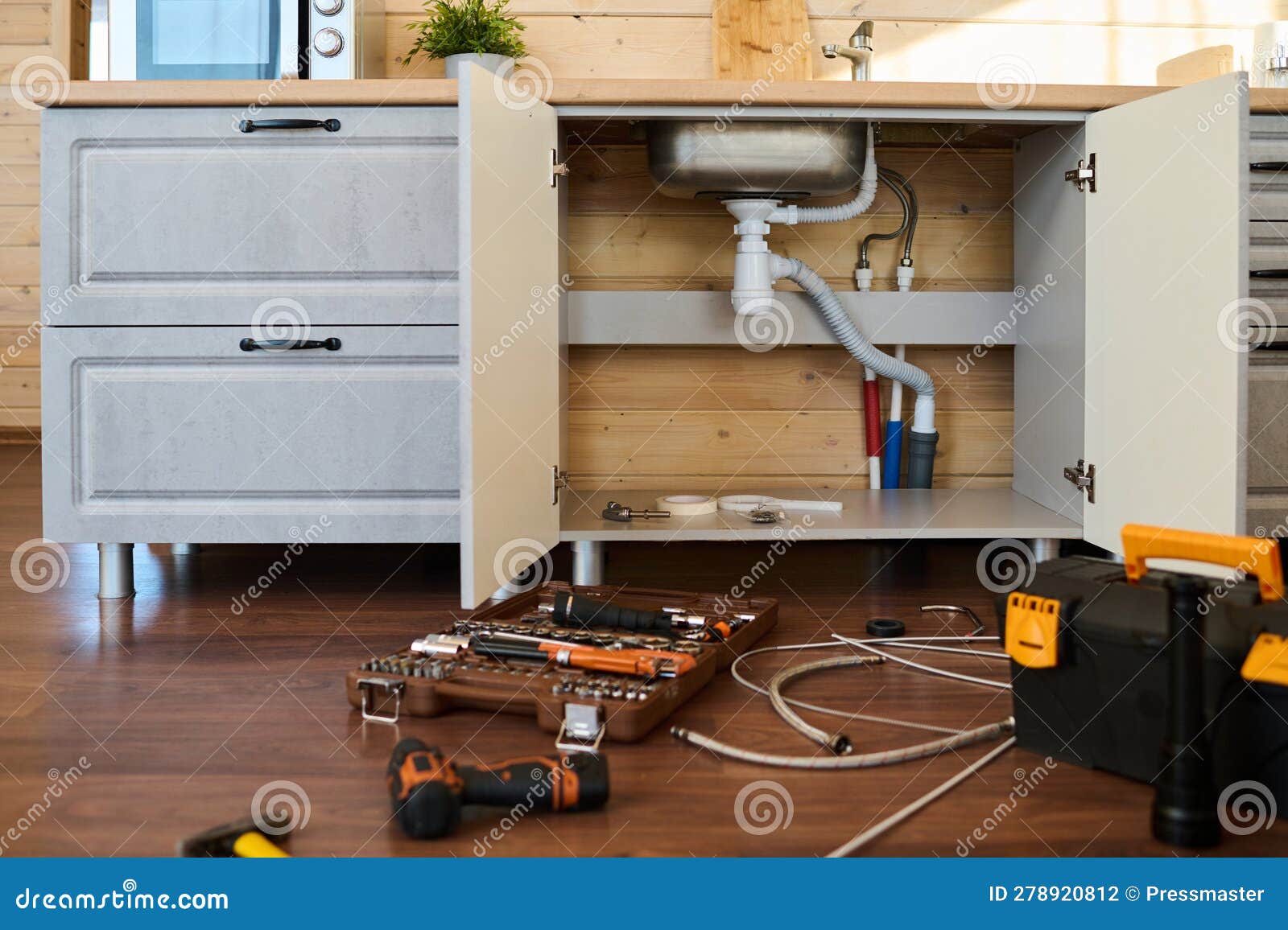 Open Cabinet of Kitchen Counter with Metallic Sink and Plastic Pipes ...