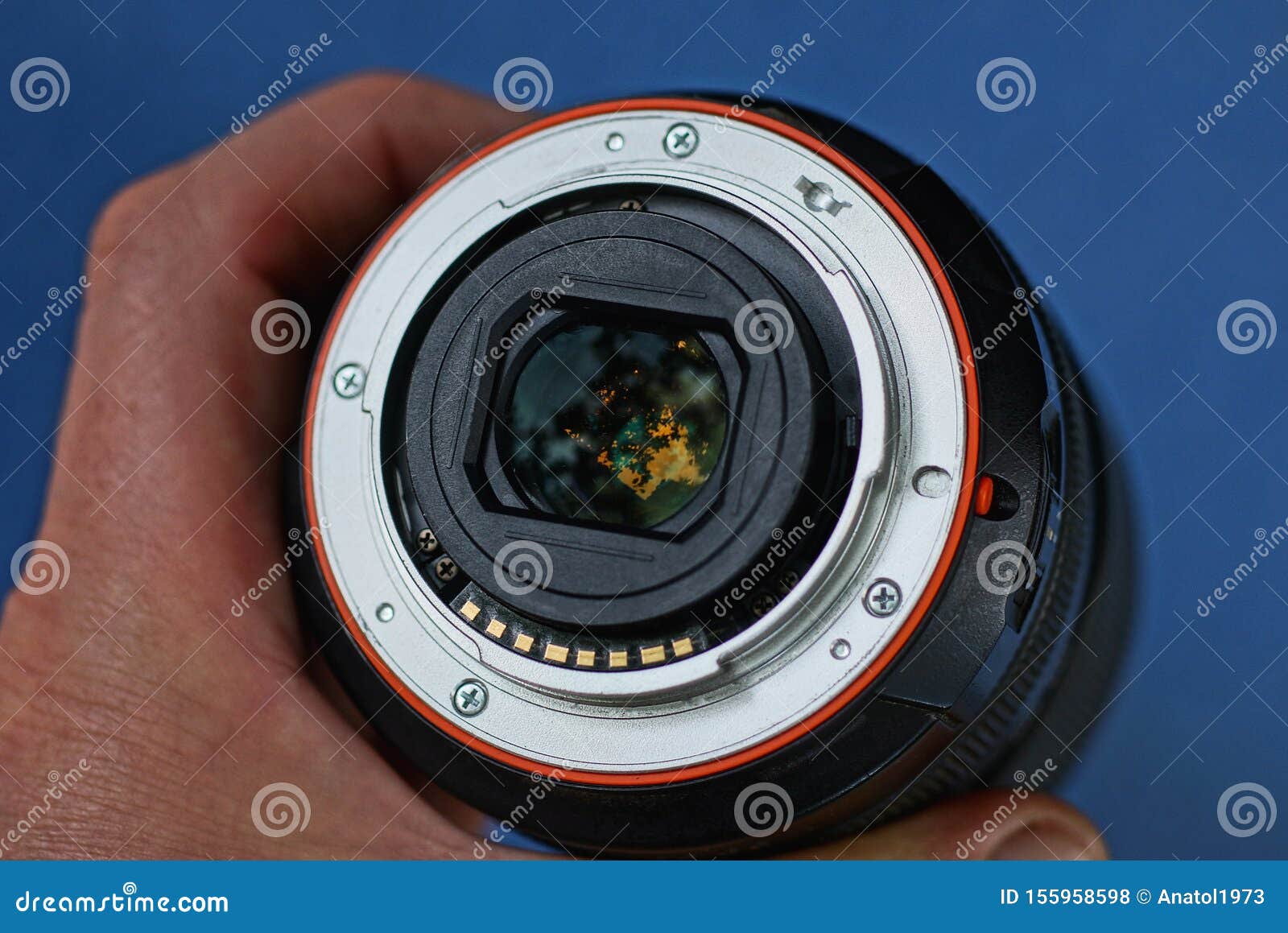 Open Camera Lens in a Hand on a Blue Background Stock Photo - Image of ...