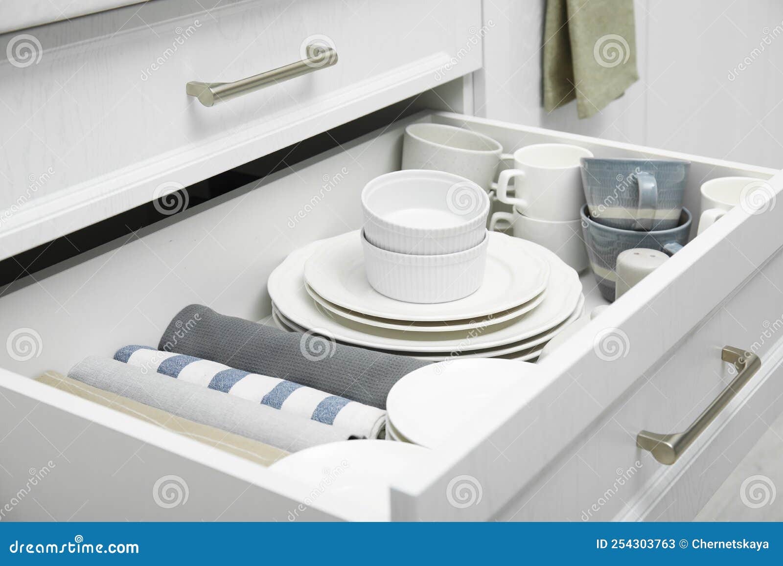 Open Drawer of Kitchen Cabinet with Different Dishware and Towels ...