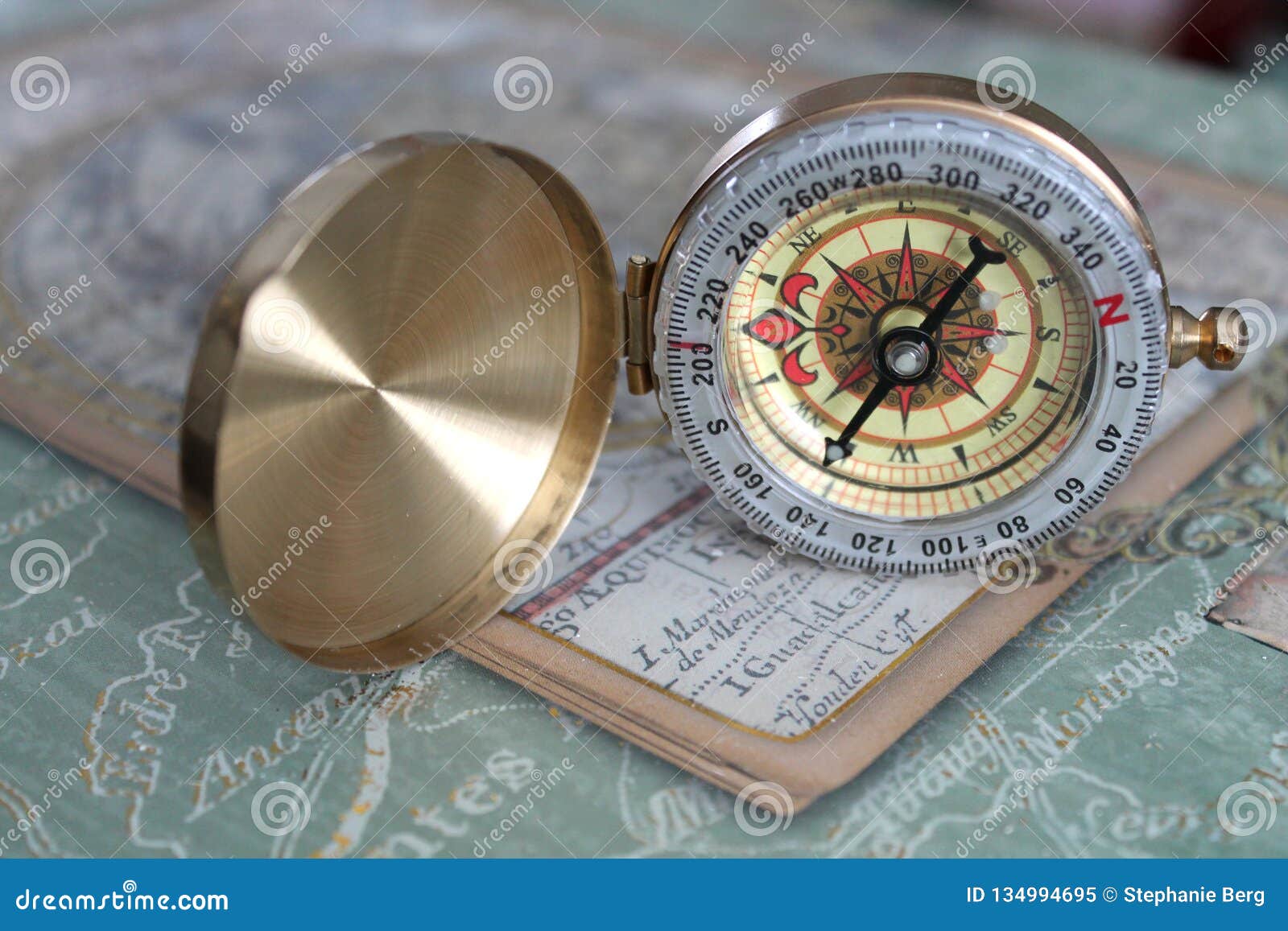 Gold Modern Compass on an Old Map Book Stock Image - Image of business ...
