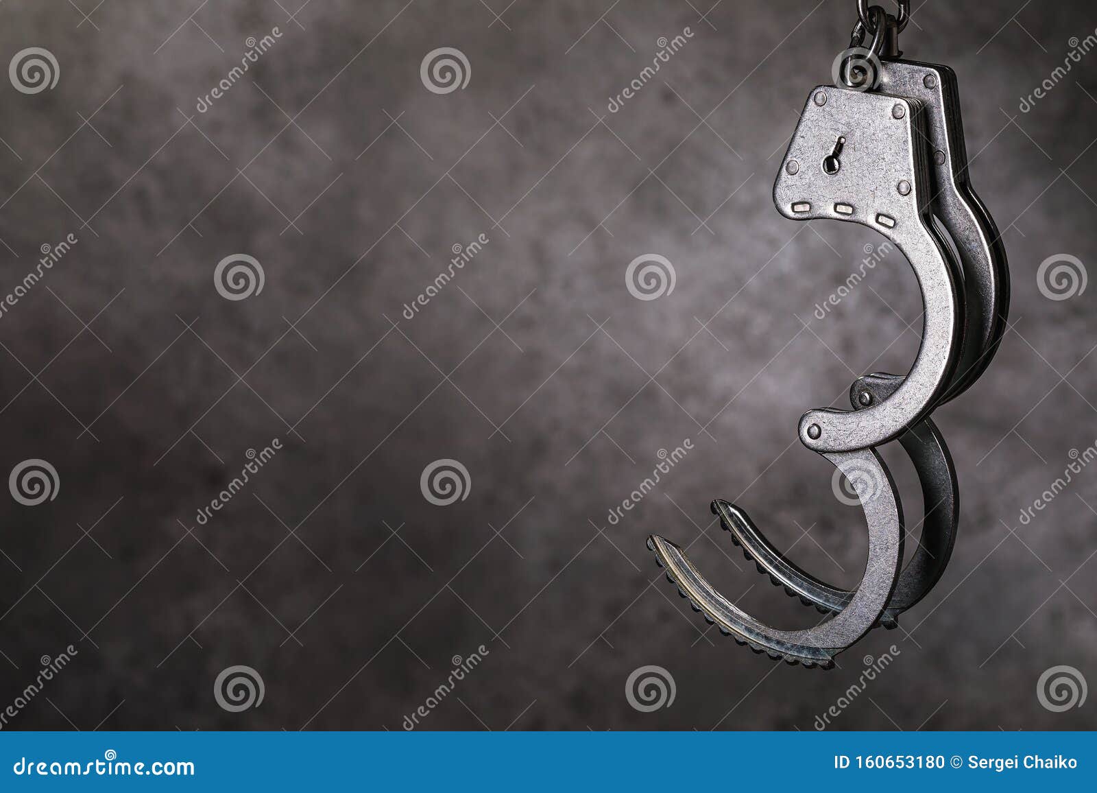 Open Handcuffs Against the Background of a Concrete Wall with a Copy of ...