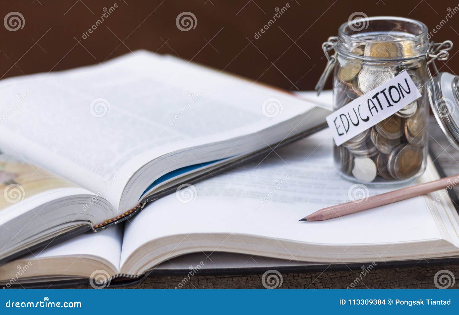 Open Hardback or Textbook Stacked and a Glass Bottle on the Table ...